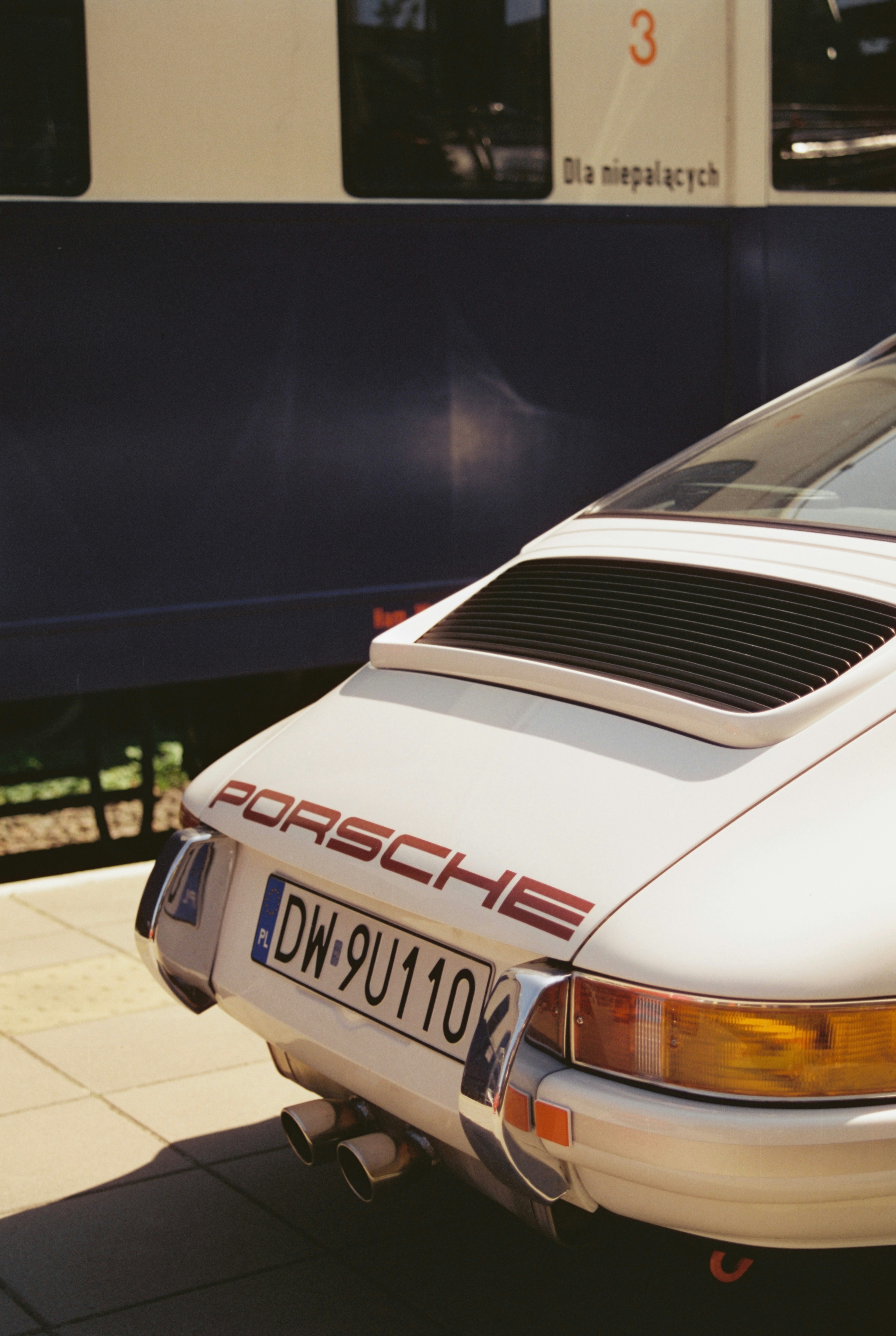Porsche Portrait: Chrome exhausts and rear emblem under a stationary platform