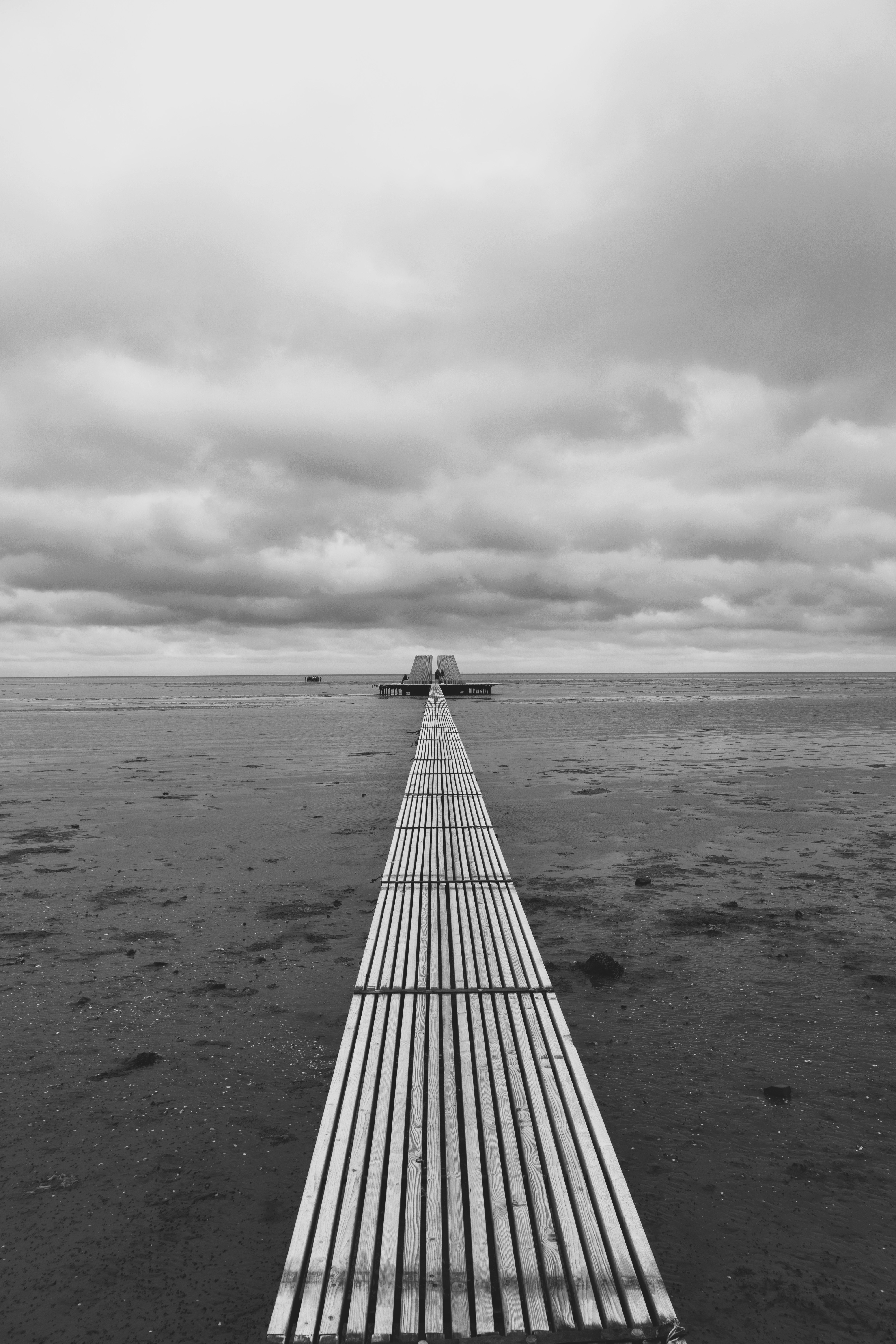 A boardwalk extends out into the cloudy sea.
