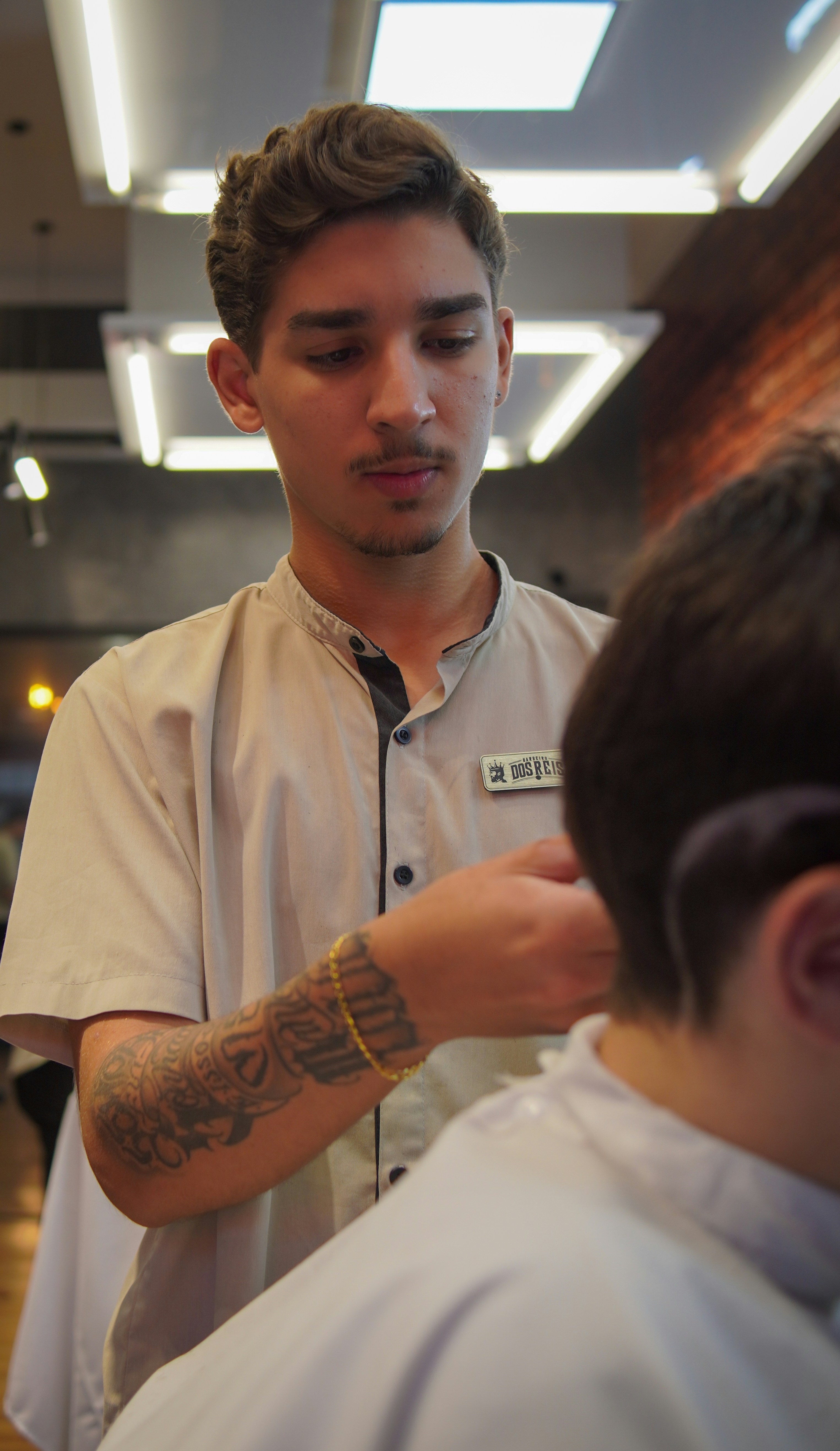 Neon Overhead Focus: A Barber at Work in Soft Salon Light