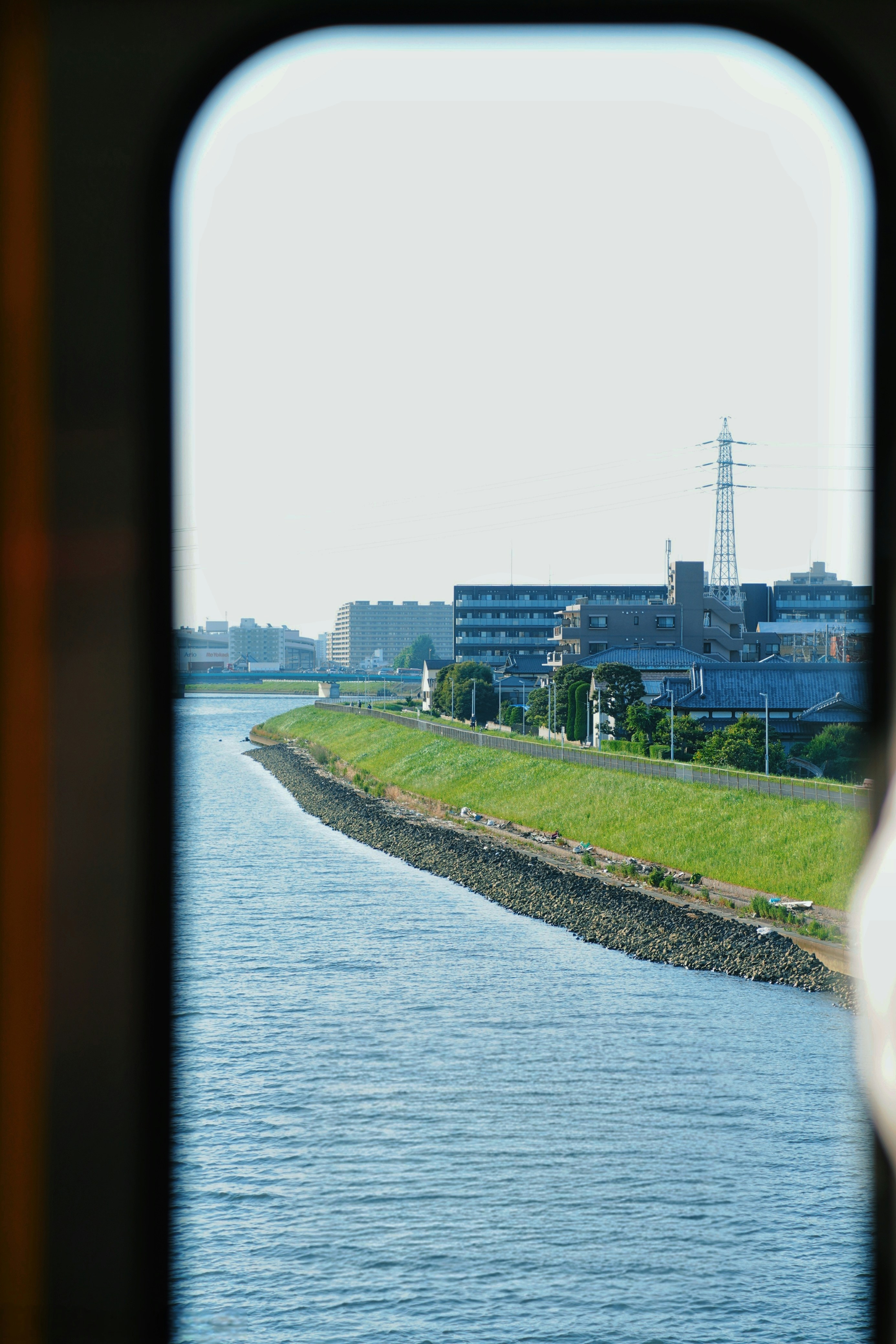 A river runs beside buildings, seen through a frame.