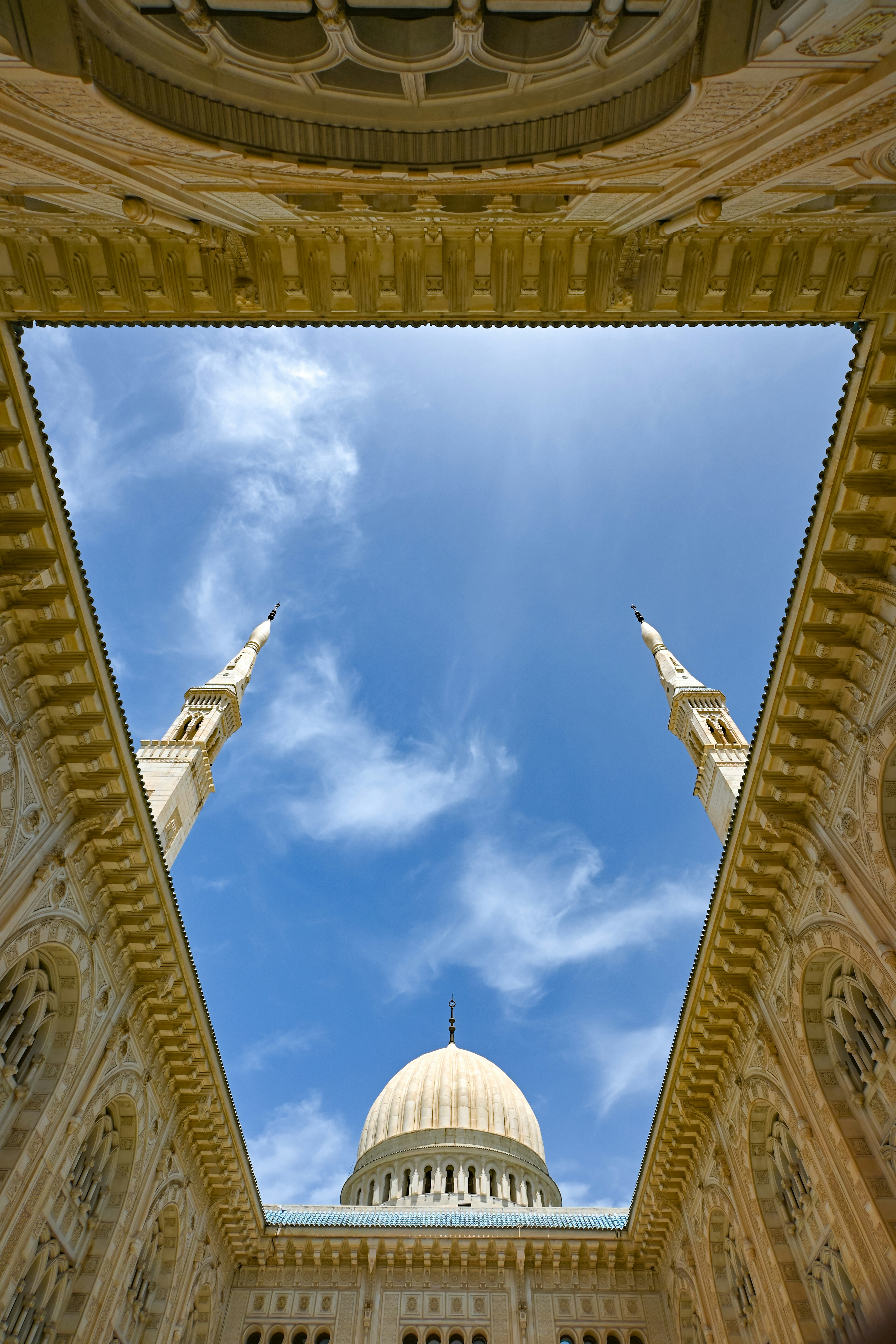 Mosque's courtyard frames the vibrant blue sky.