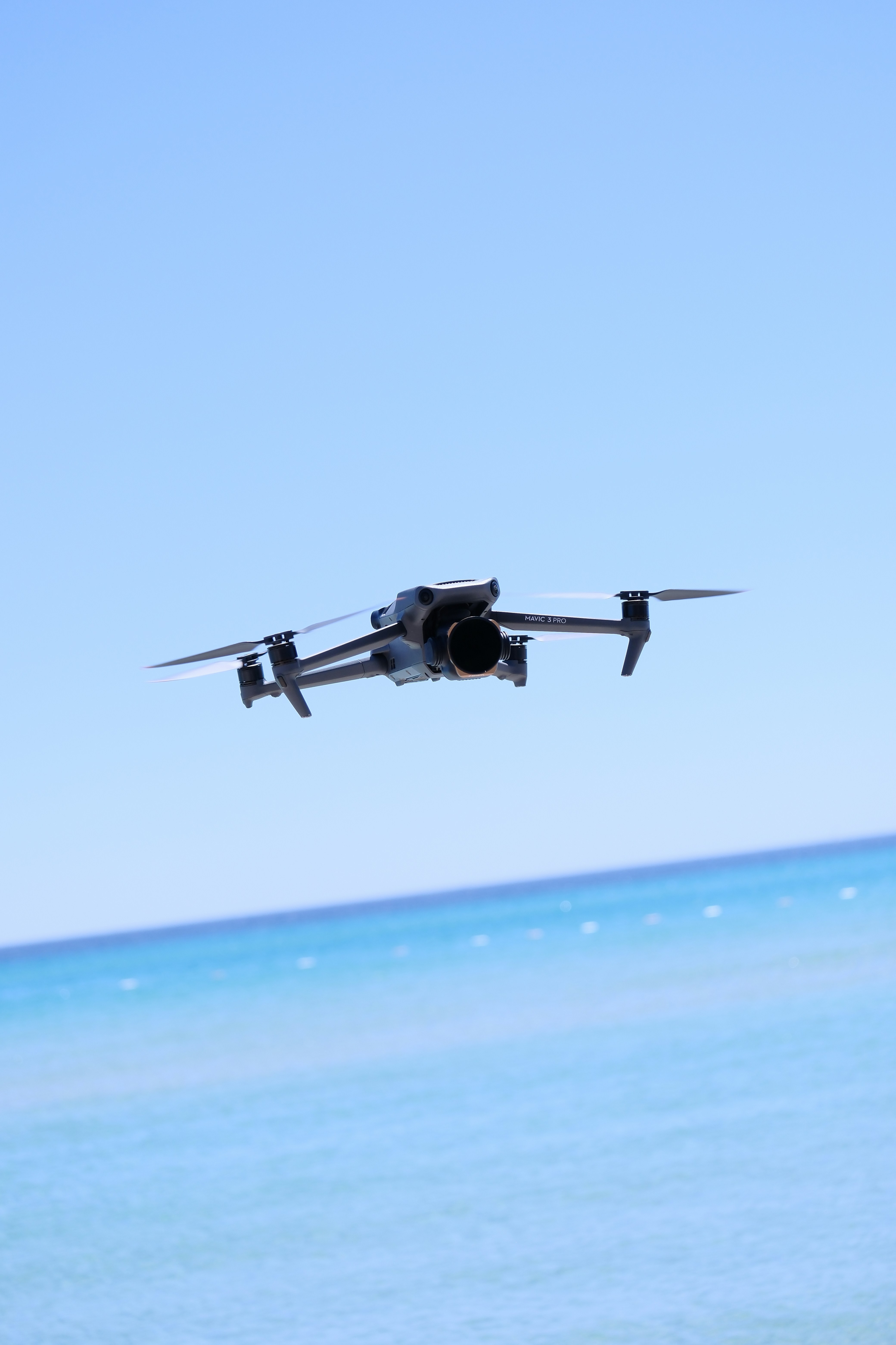 A drone flies above the ocean.
