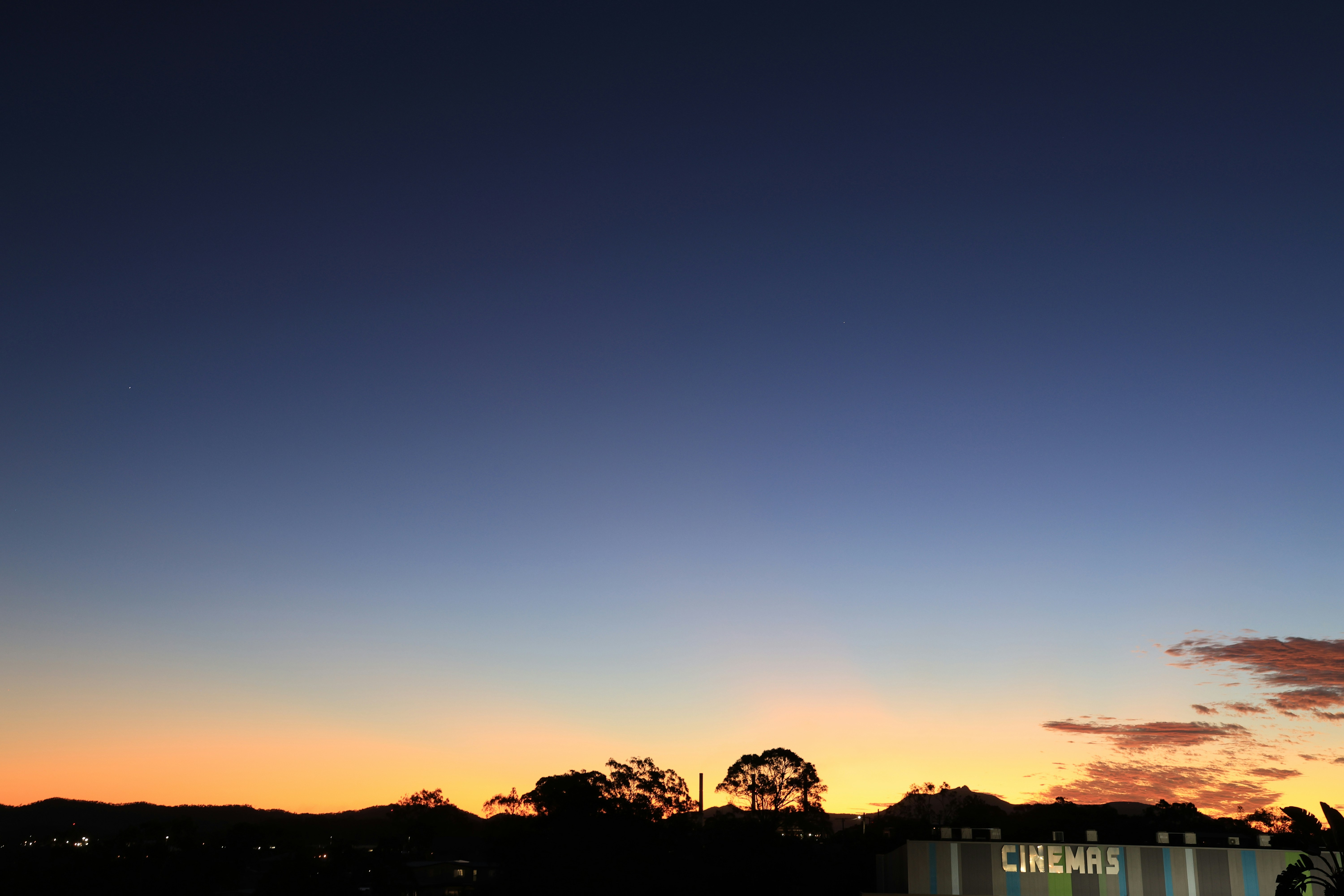 Dusk descends over the horizon and a theater.