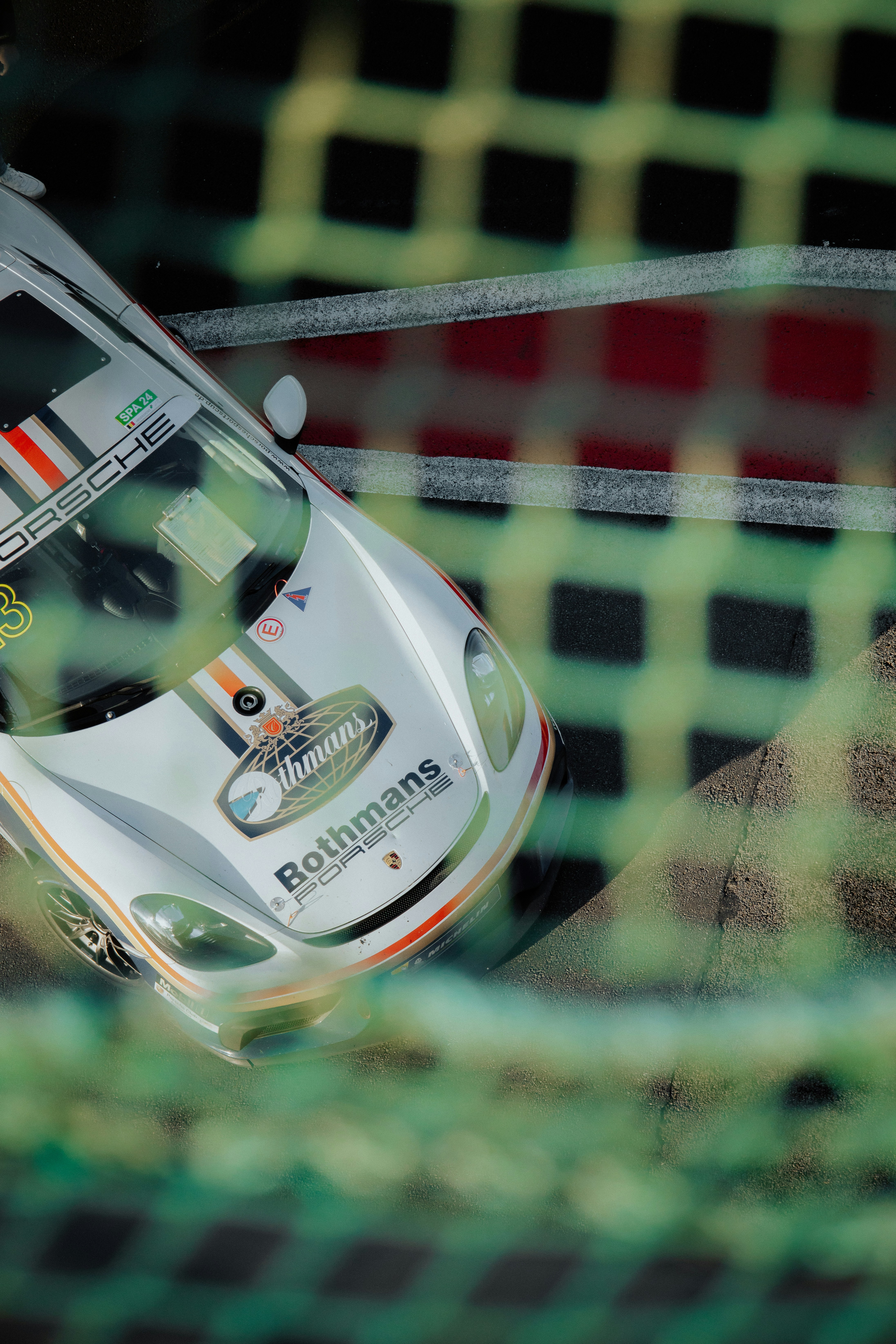 A miniature porsche race car is on a track.