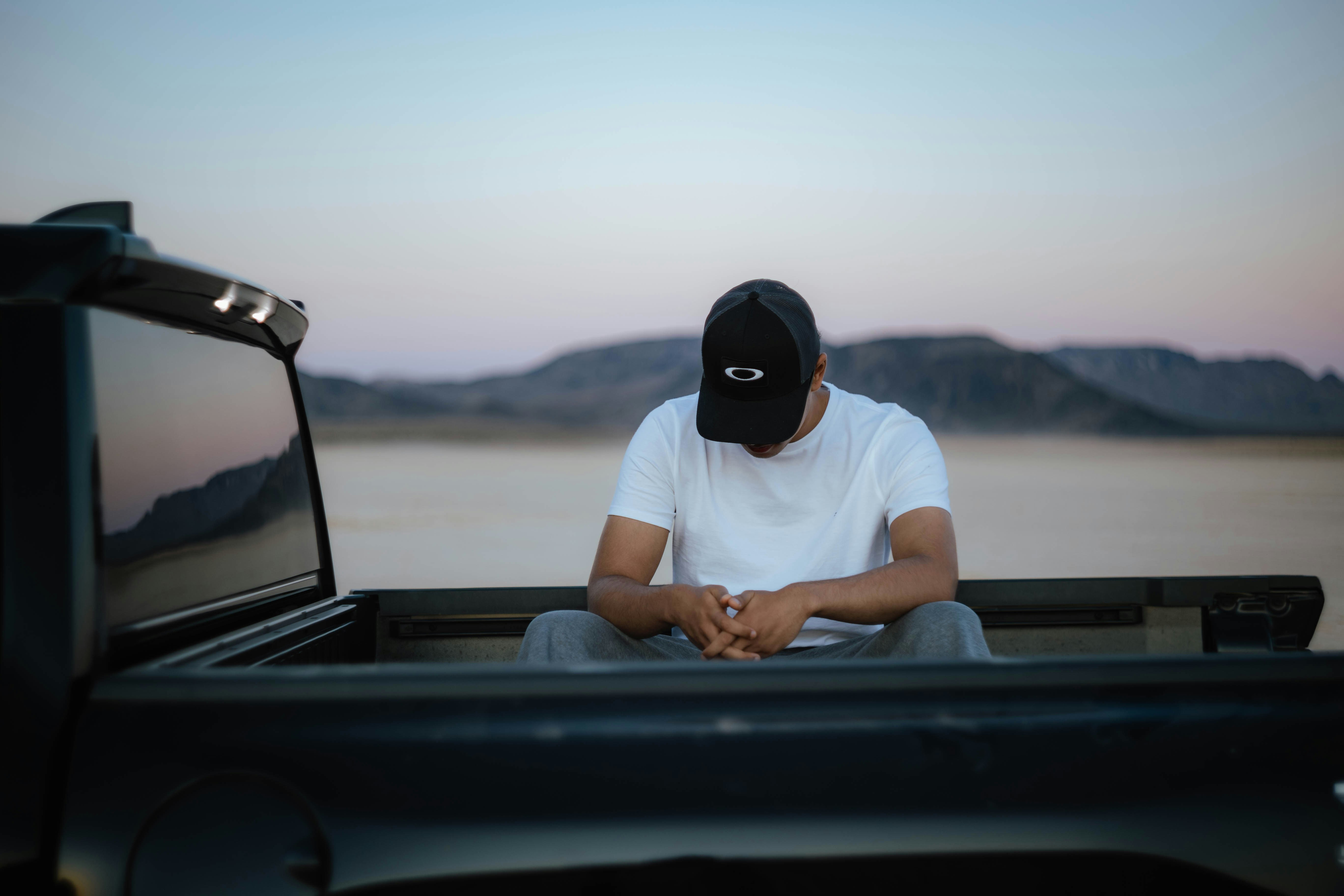 Quiet Moment in the Truck Bed: A Hoodie and Cap Vanish into the Dusk