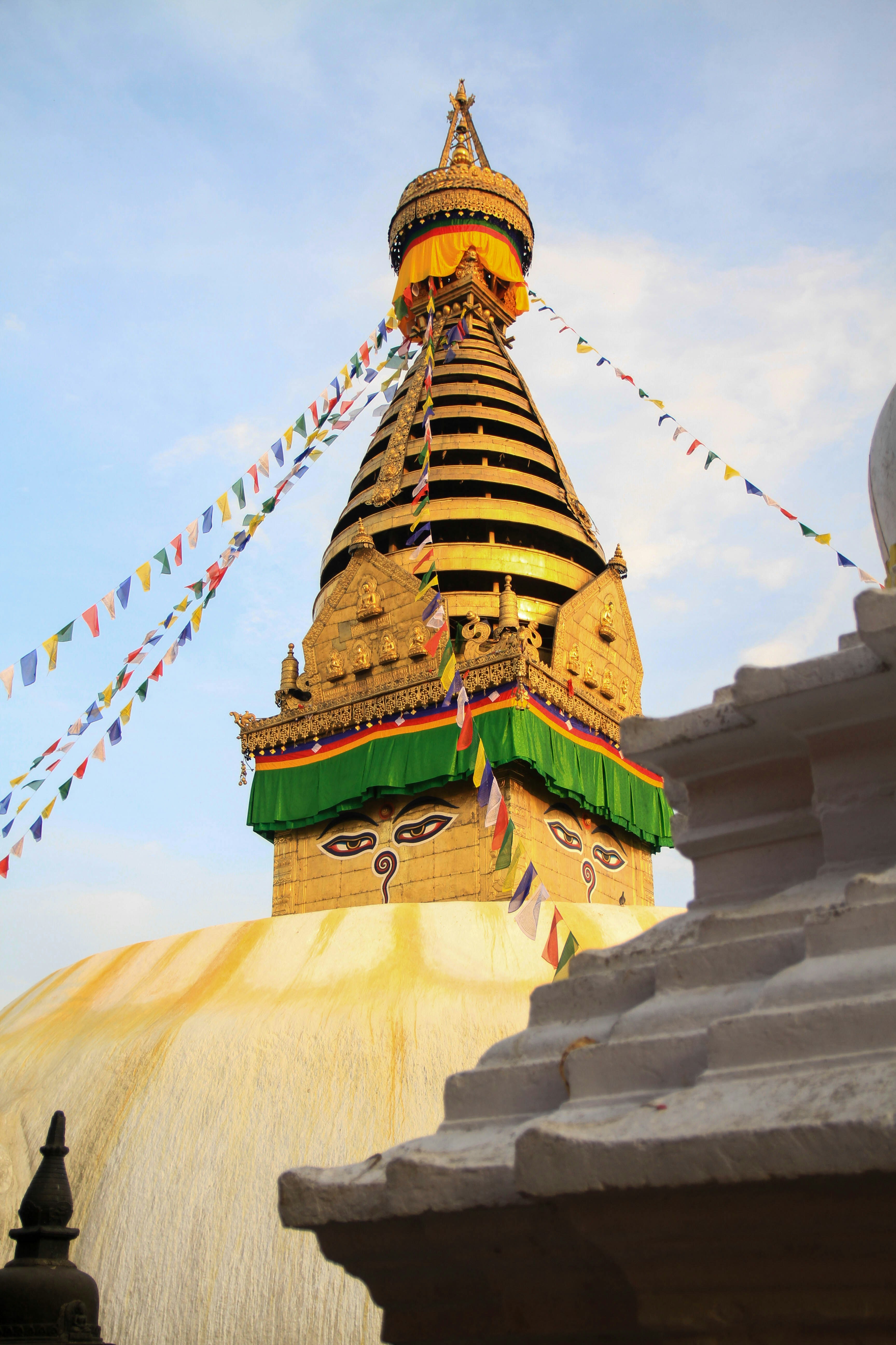Whispers of devotion. A golden stupa adorned with vibrant prayer flags, framed by ancient architecture in Kathmandu. A moment of peace and wonder. | A golden temple shimmers against the sky.