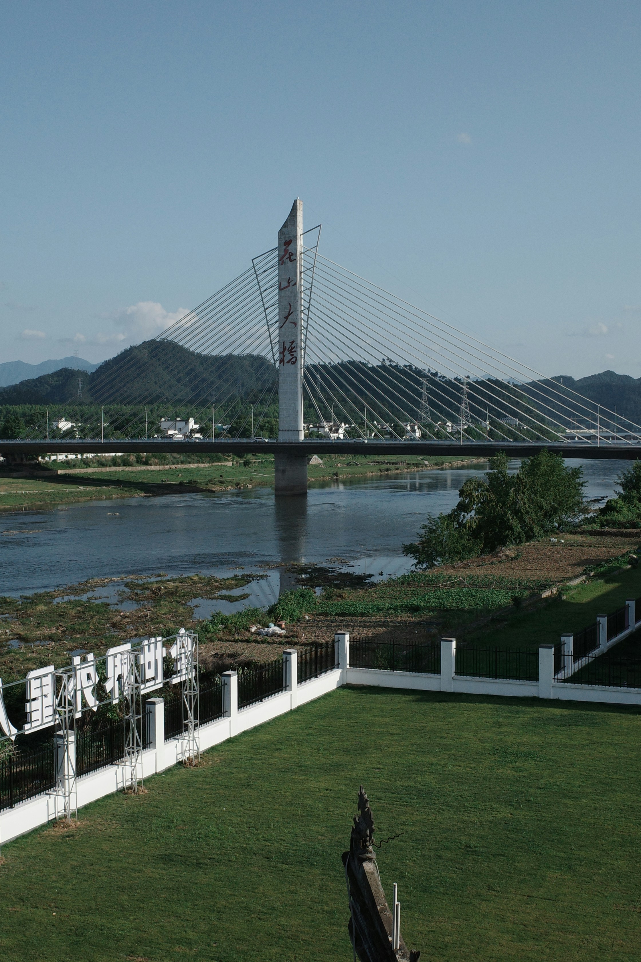 A modern bridge spans a river in a scenic location.