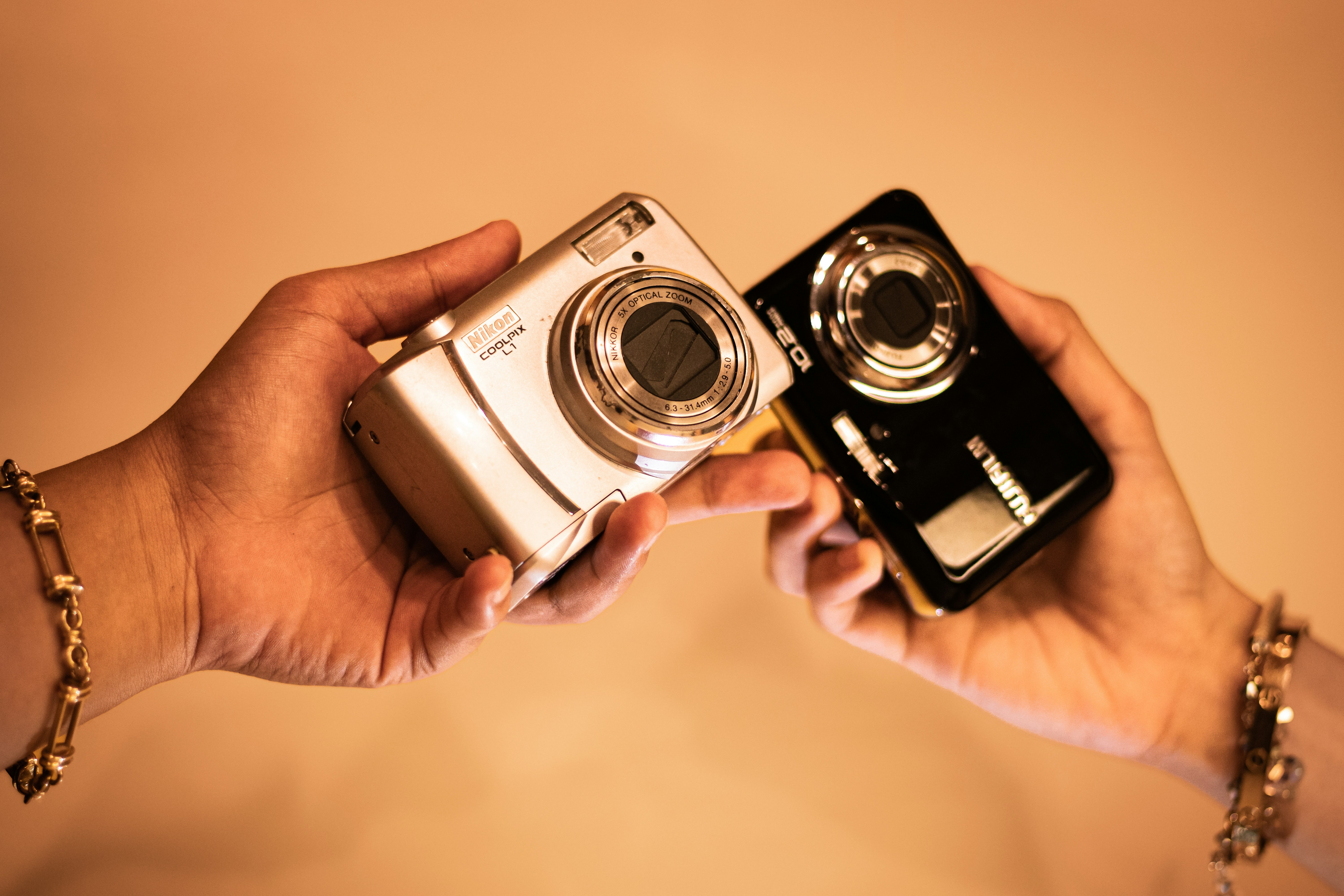 Two cameras held up in the air.