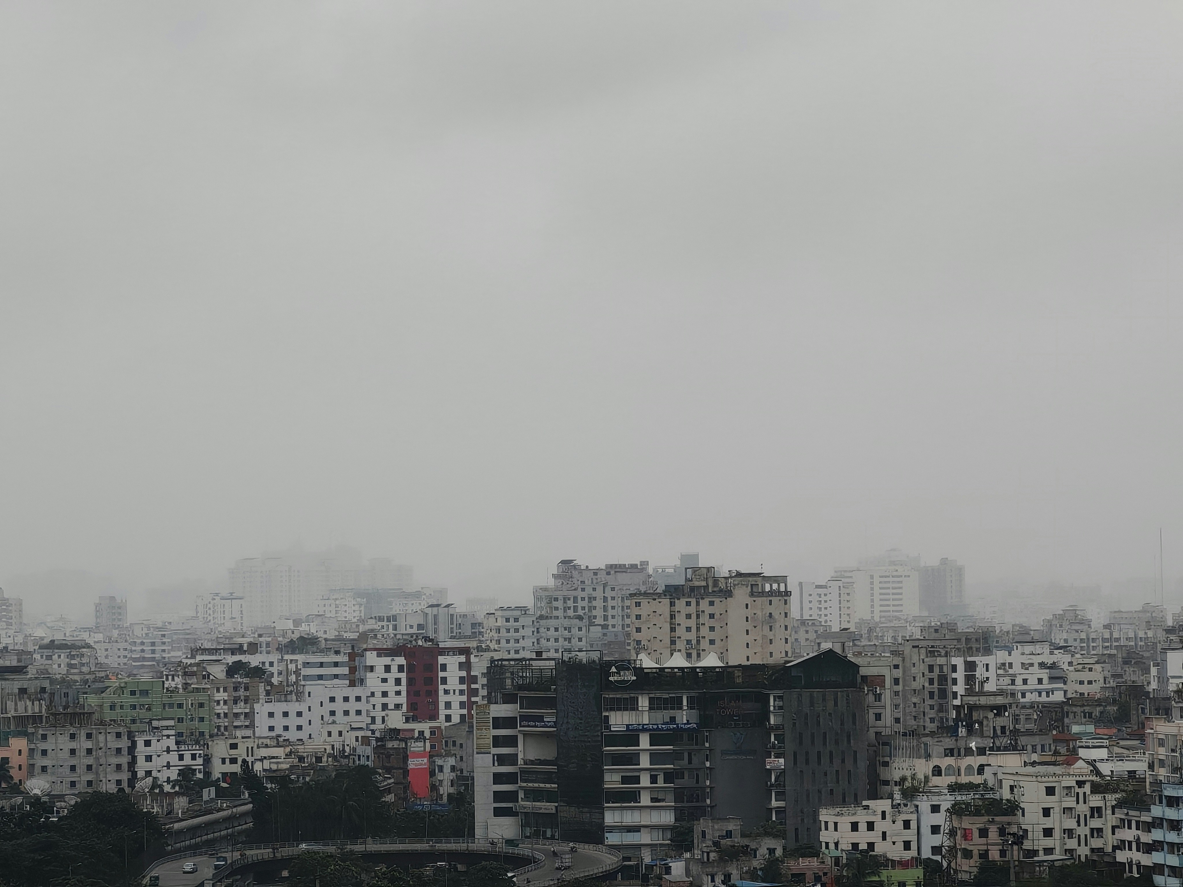 Cityscape shrouded in overcast sky and fog.