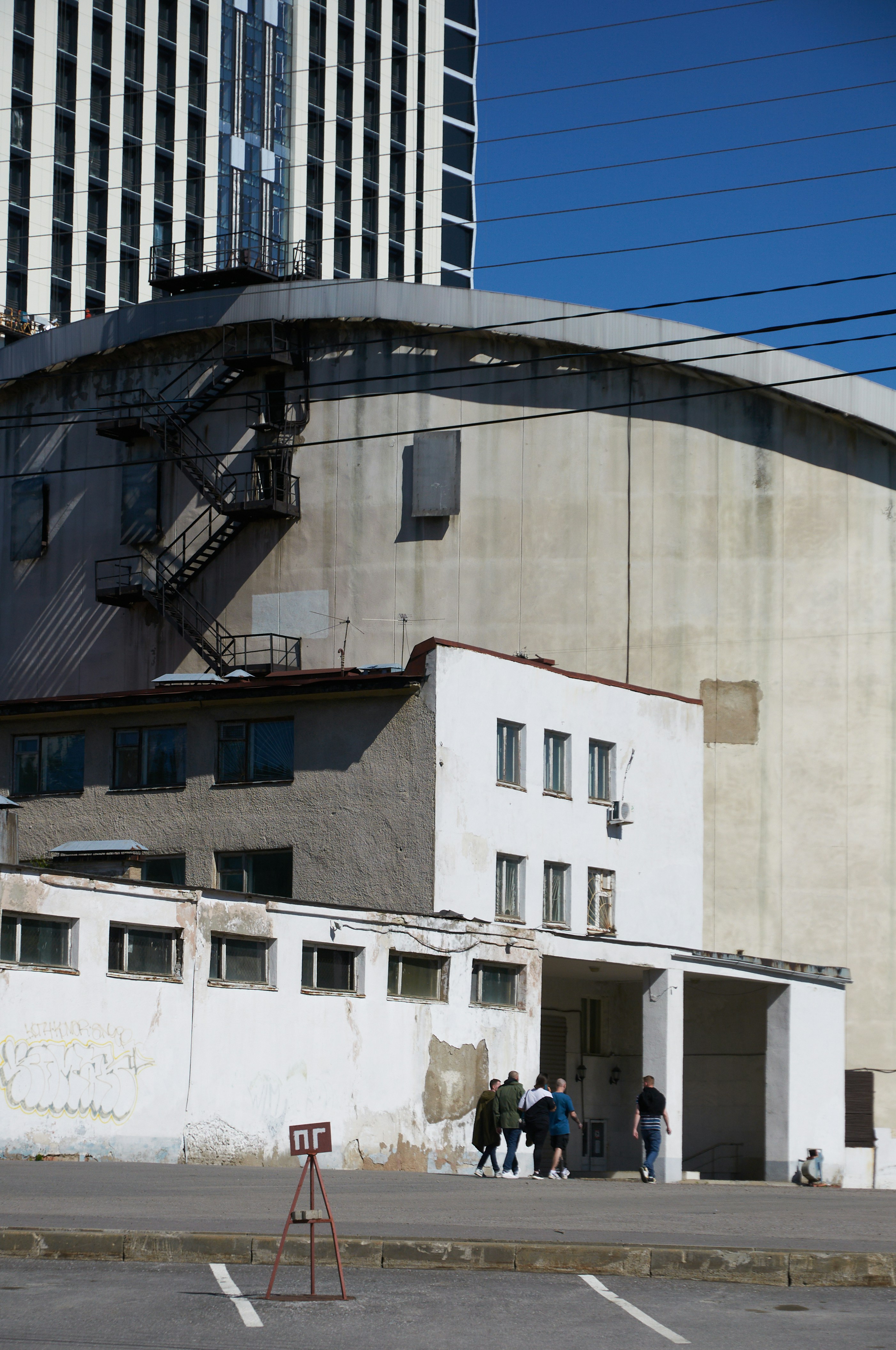 Urban landscape features an industrial building and people.