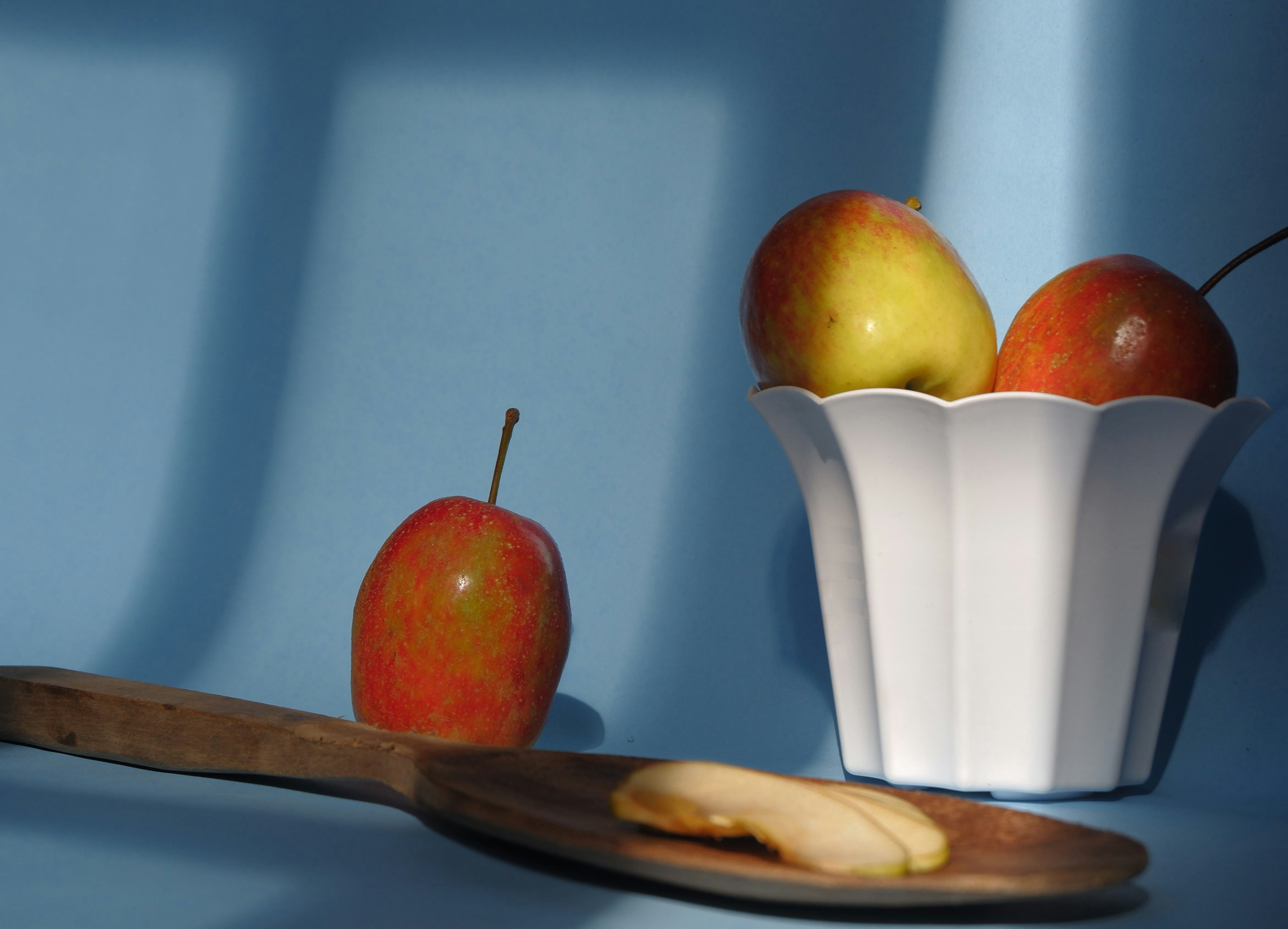 A split apple with a blue background, a perfect photo for a food flogger | Apples and a spoon are on a blue background.