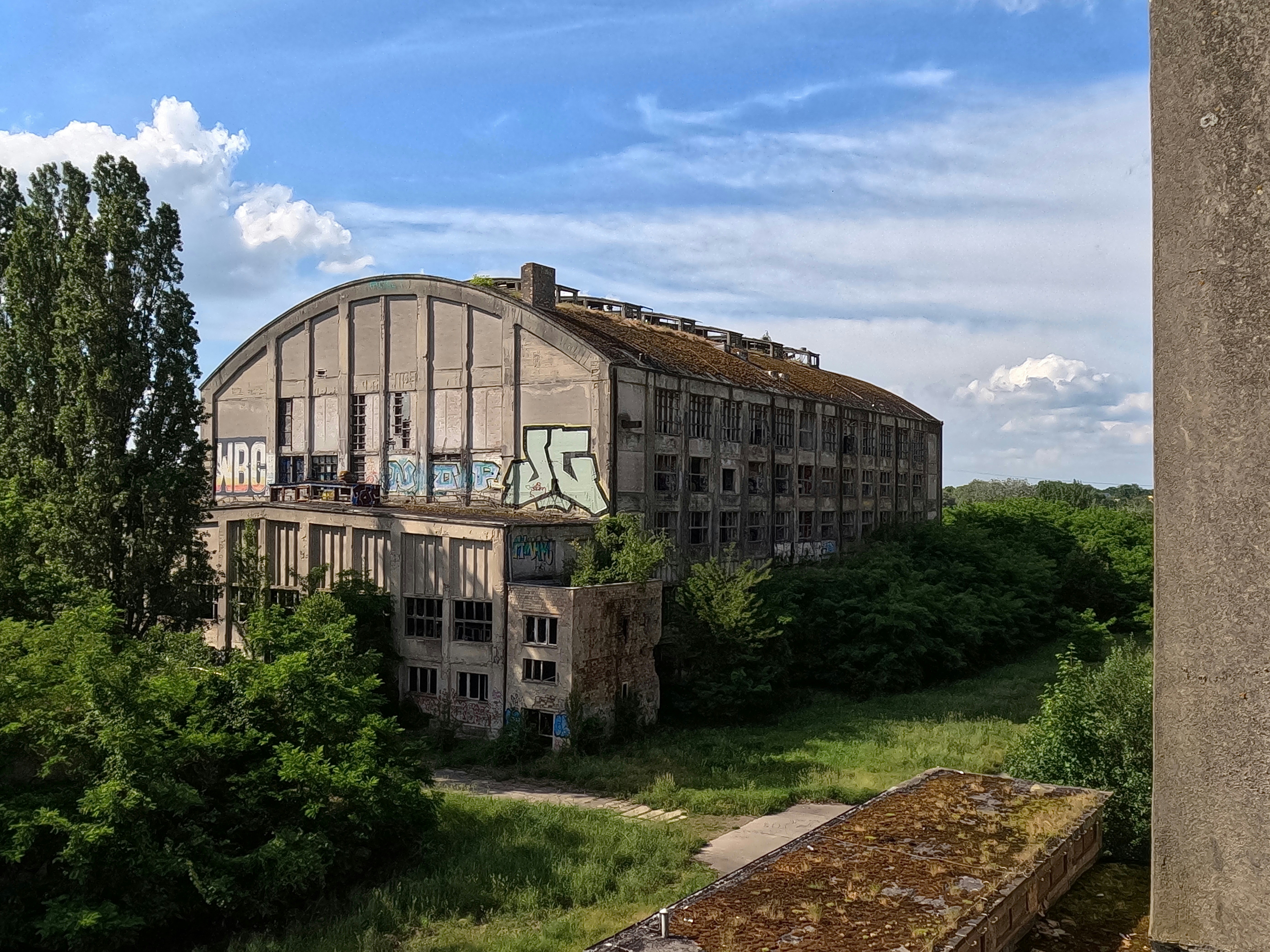 An abandoned, decaying concrete building is shown.