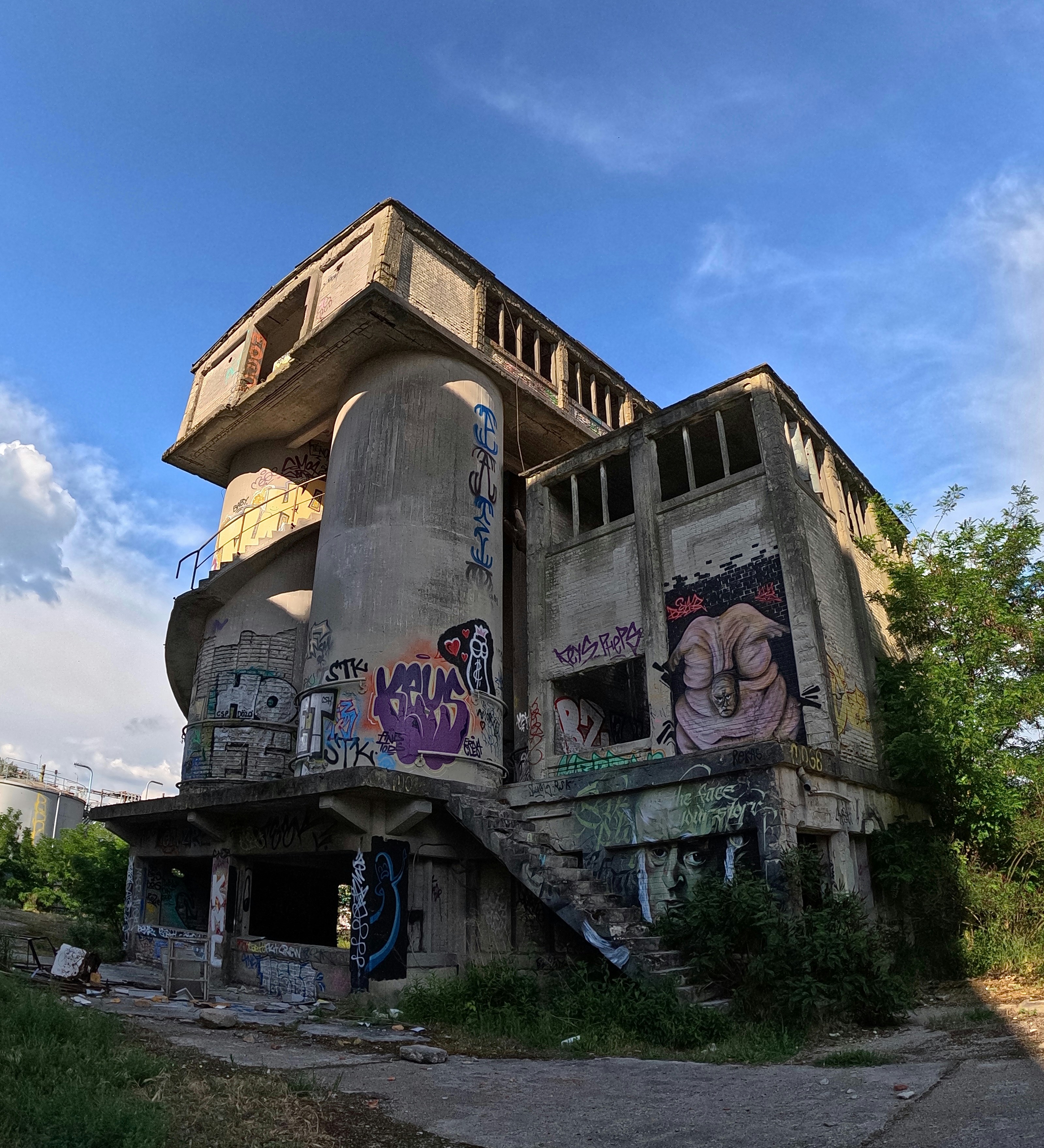 Graffiti-covered, abandoned building under a blue sky.
