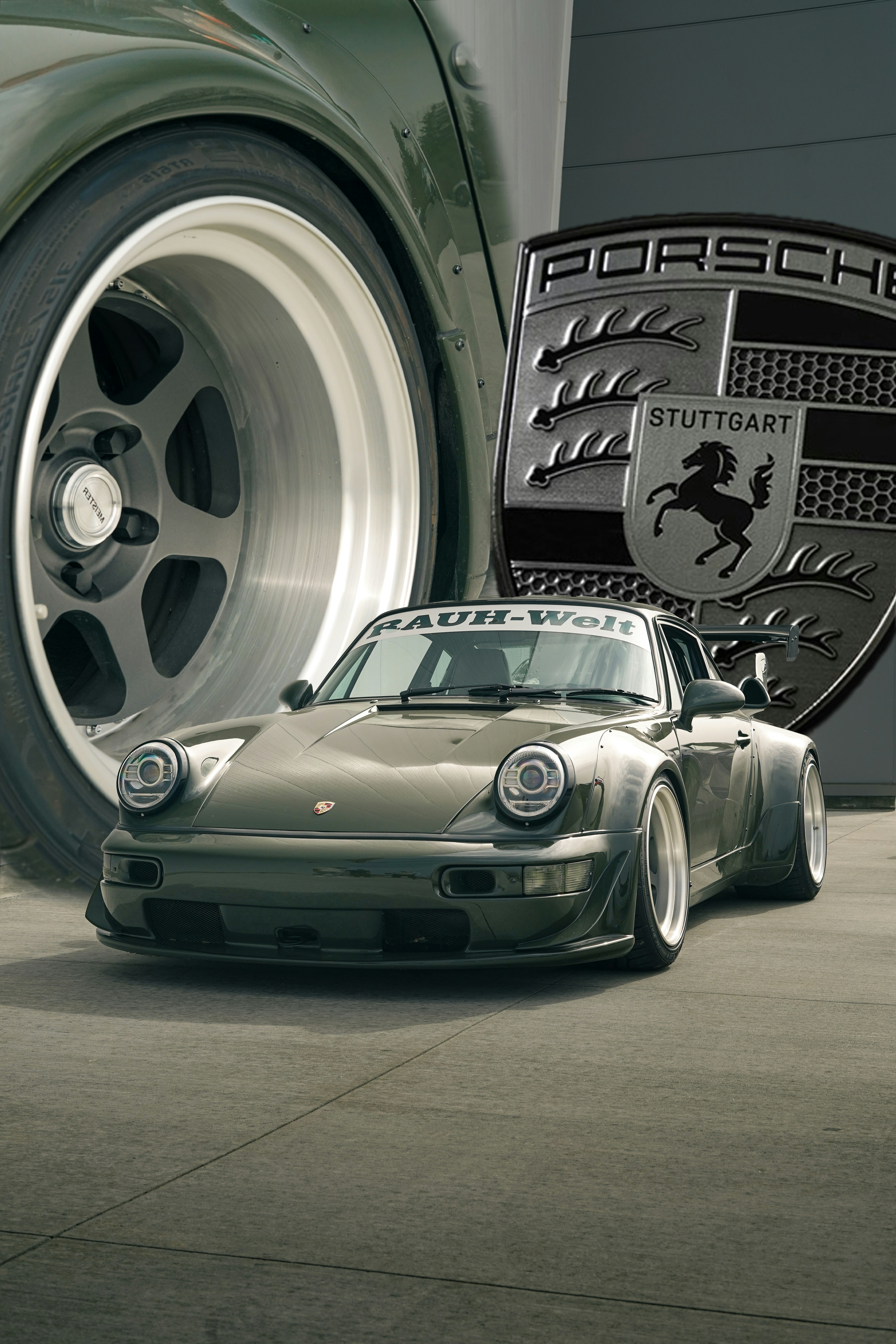 A modified Porsche 911 with a sleek body kit and custom wheels, set against a backdrop featuring the iconic Porsche crest. The image showcases automotive craftsmanship and style.