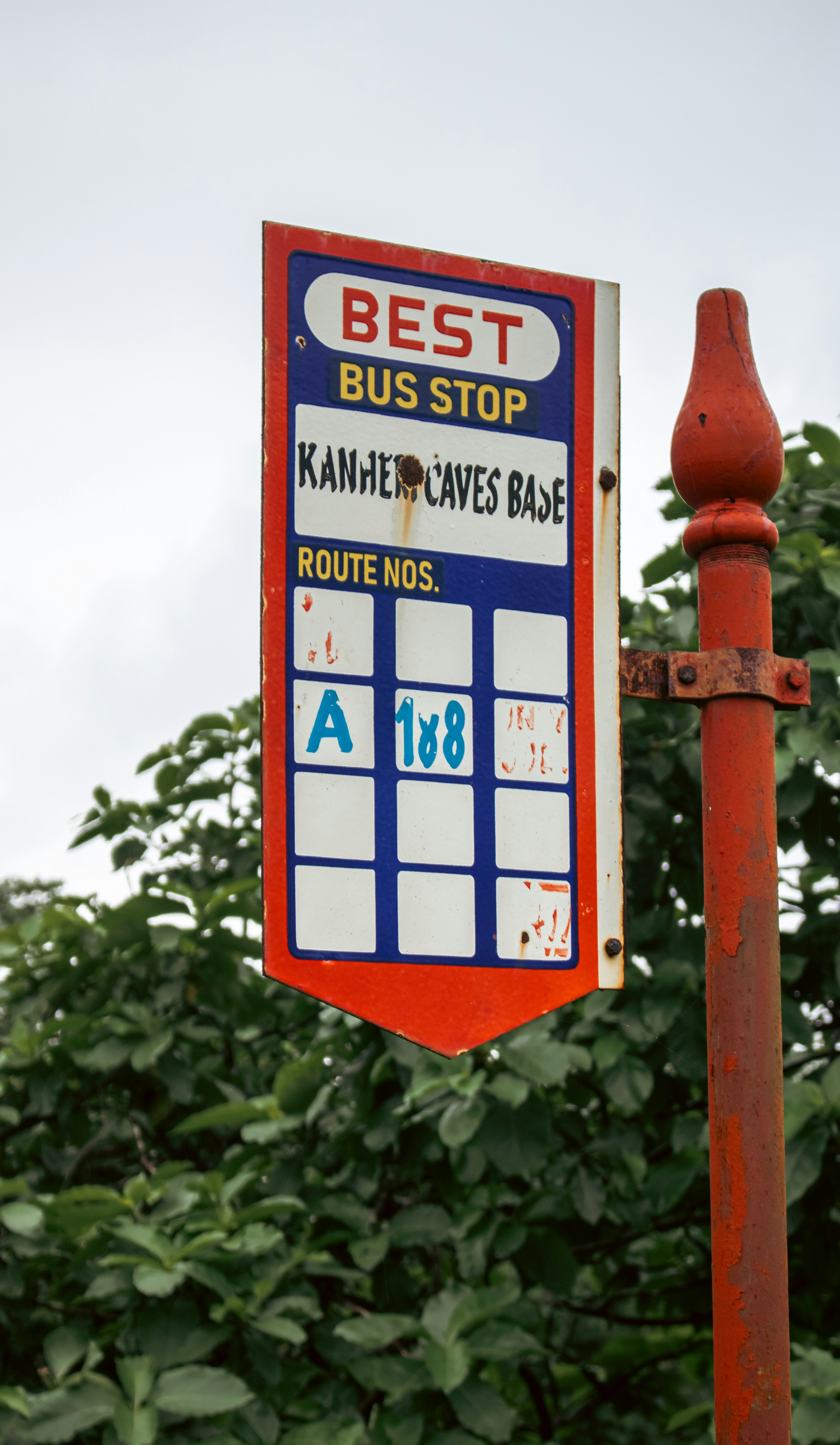 A bus stop sign with route numbers. photo – Free India Image on Unsplash