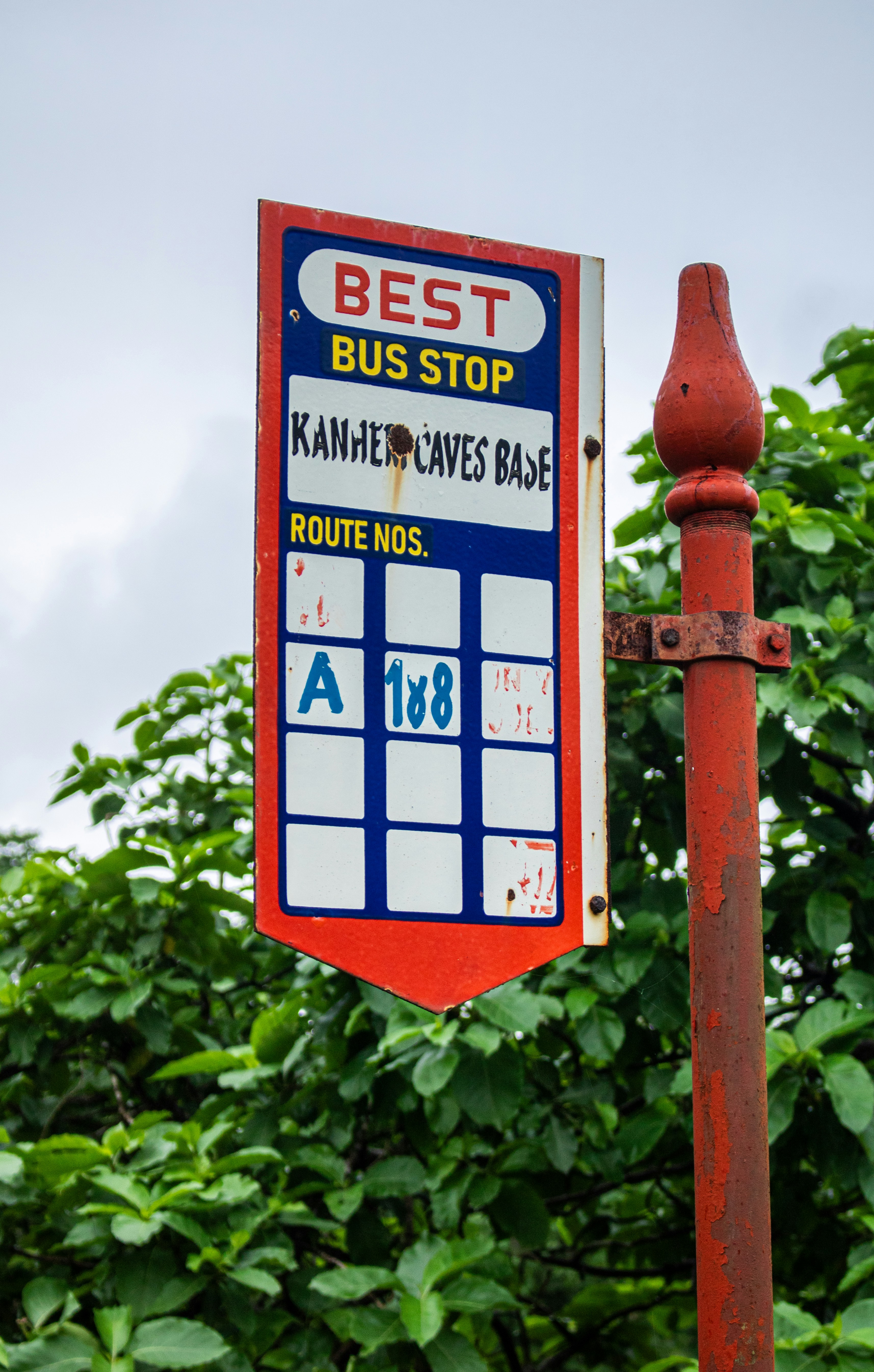 A close-up view of a bus stop sign displaying the bus numbers that halt at the stop. | A weathered sign indicates a best bus stop.