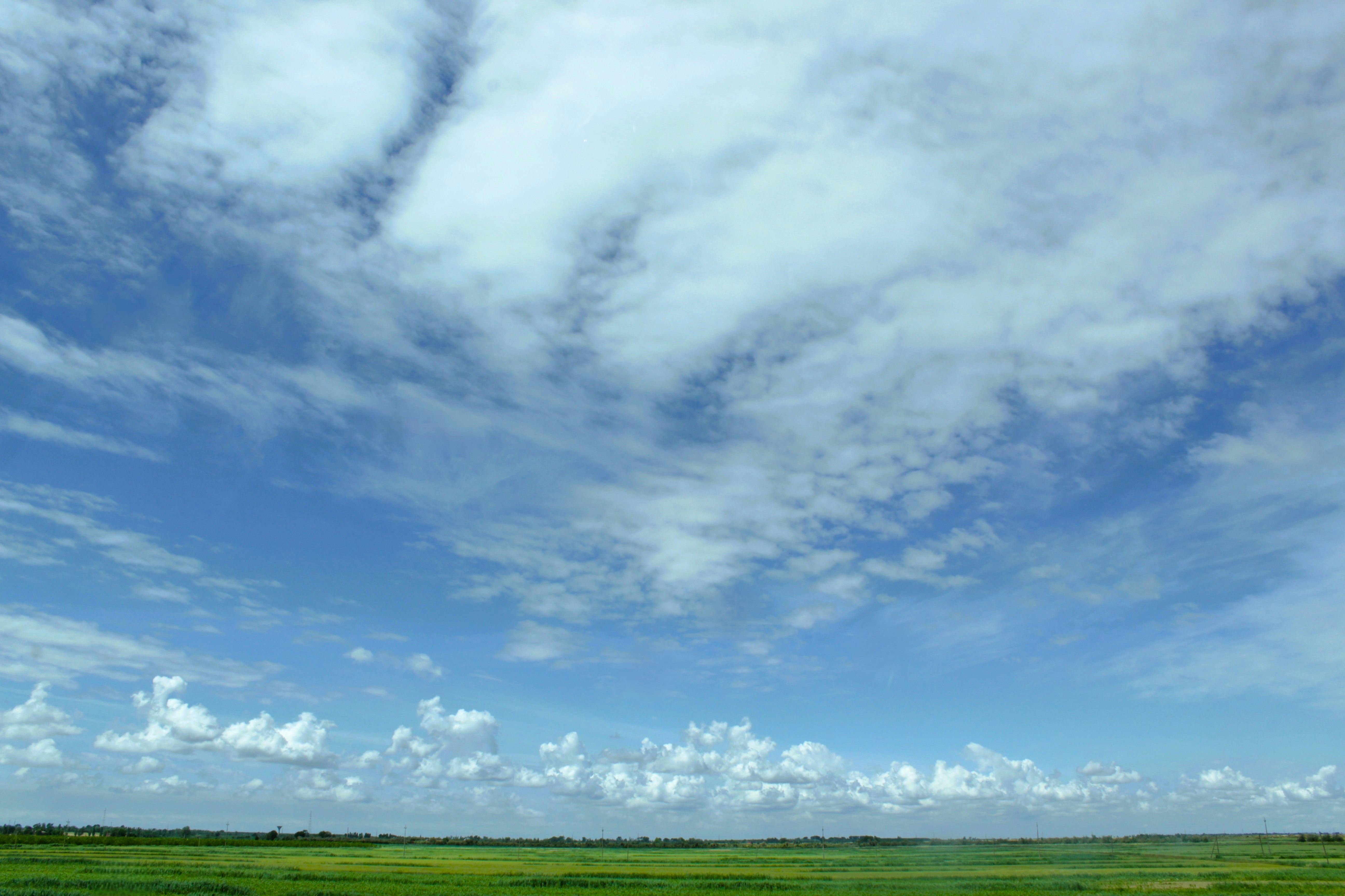 Blue sky and fluffy clouds over green field. photo – Free Clouds Image ...