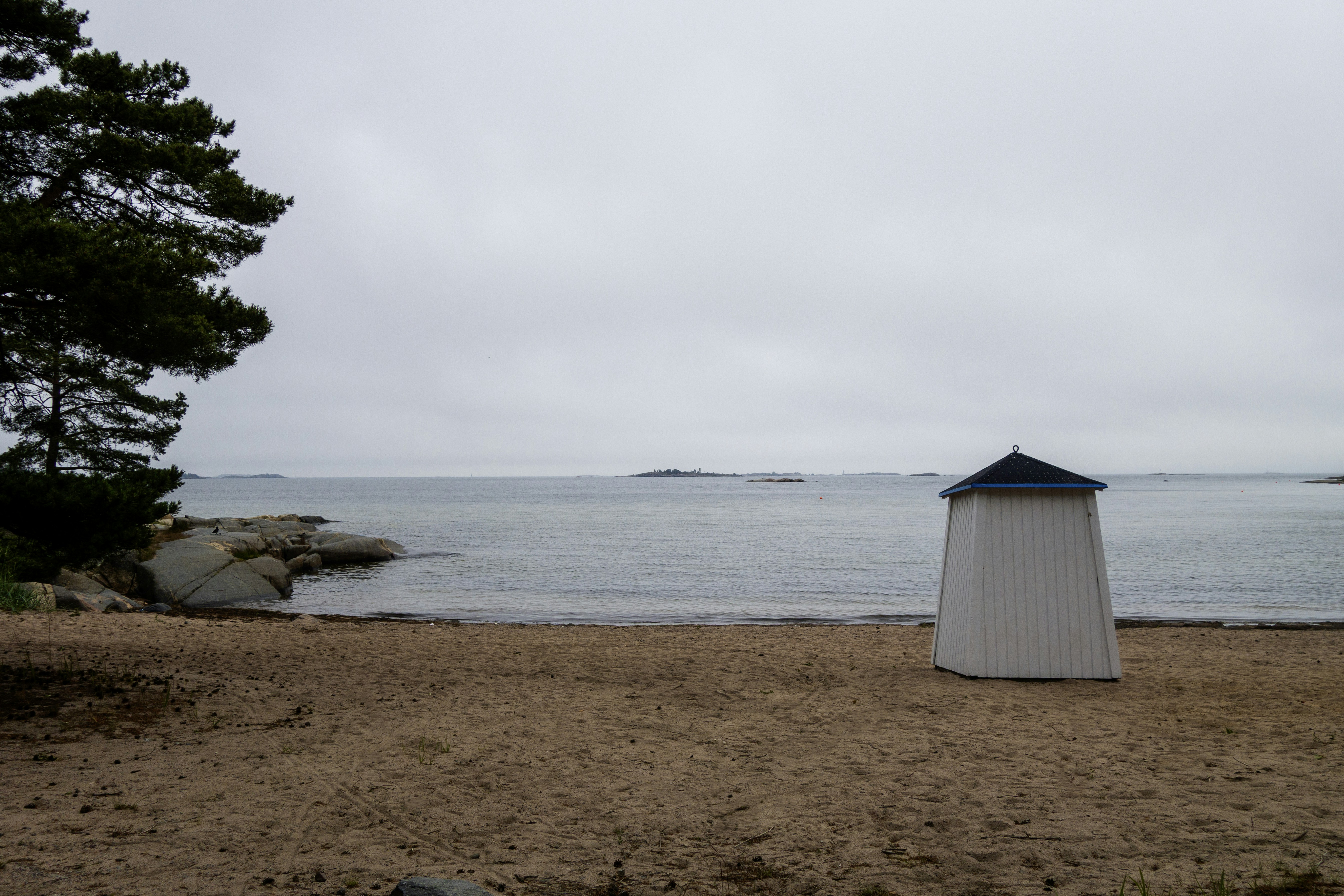 Beach view from Hanko Finland | Beach with a changing room under a grey sky.