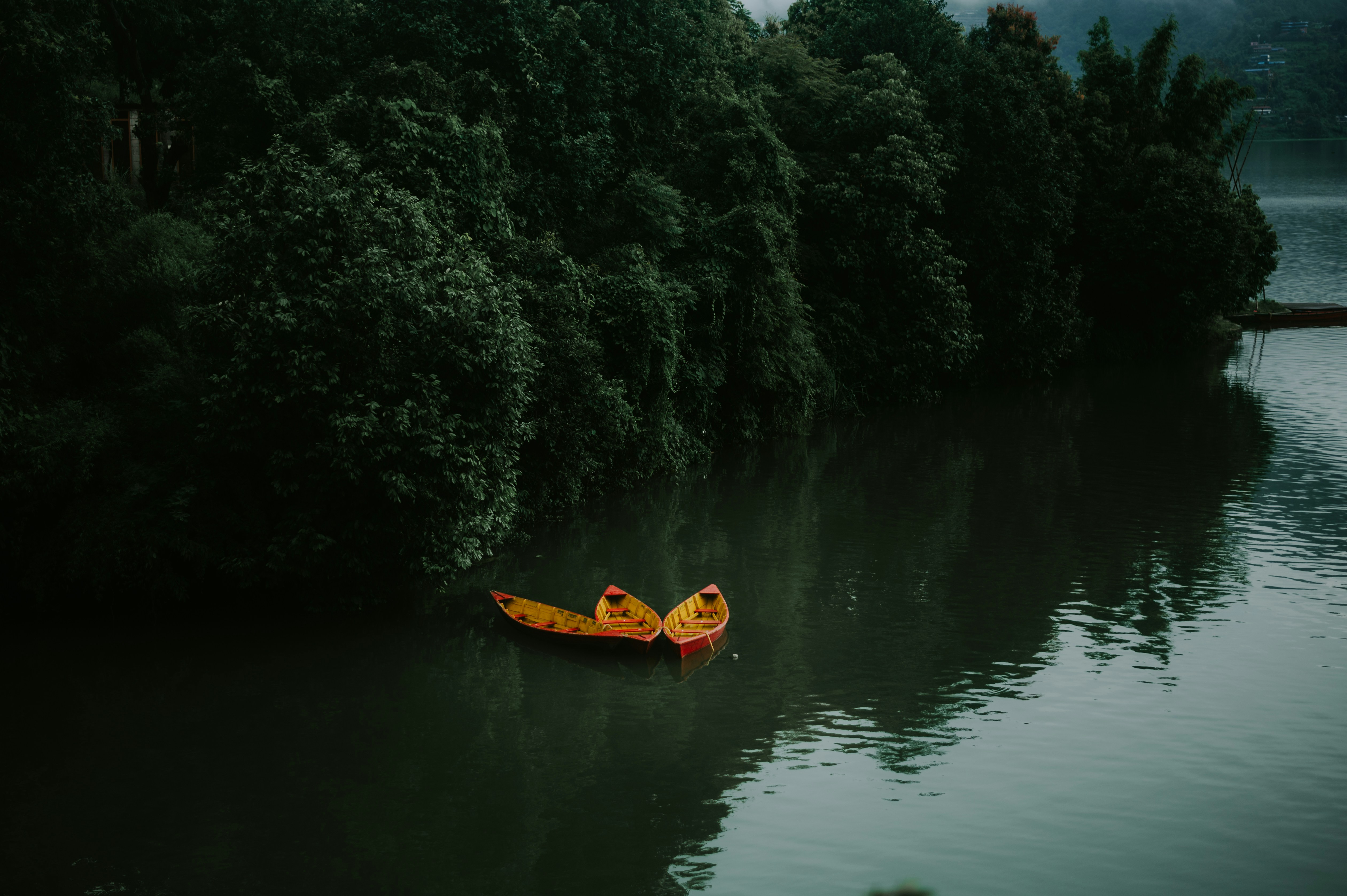 Boat floats peacefully on a dark lake.