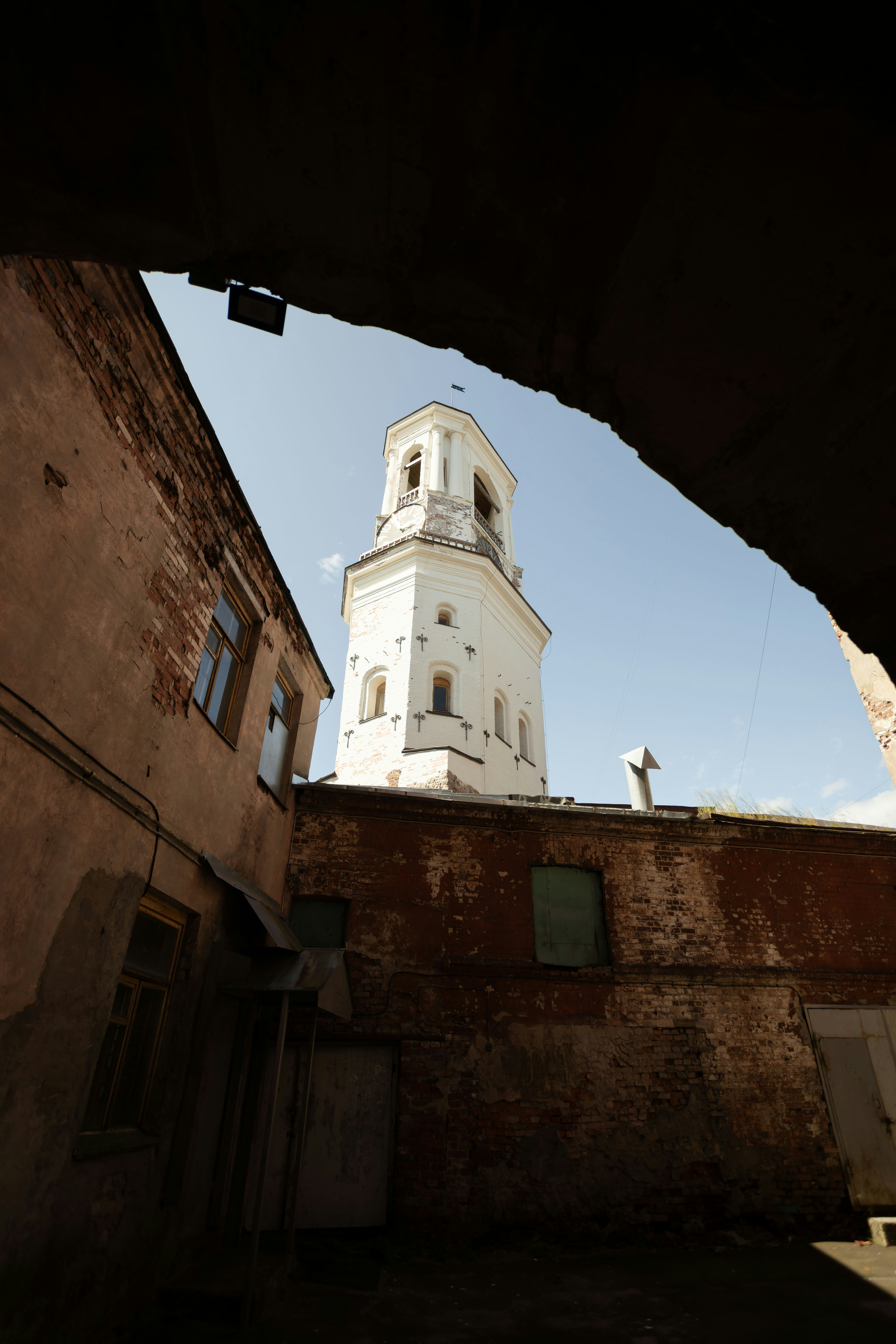 Archway Dawn: The Bell Tower Rising Over a Brick Courtyard