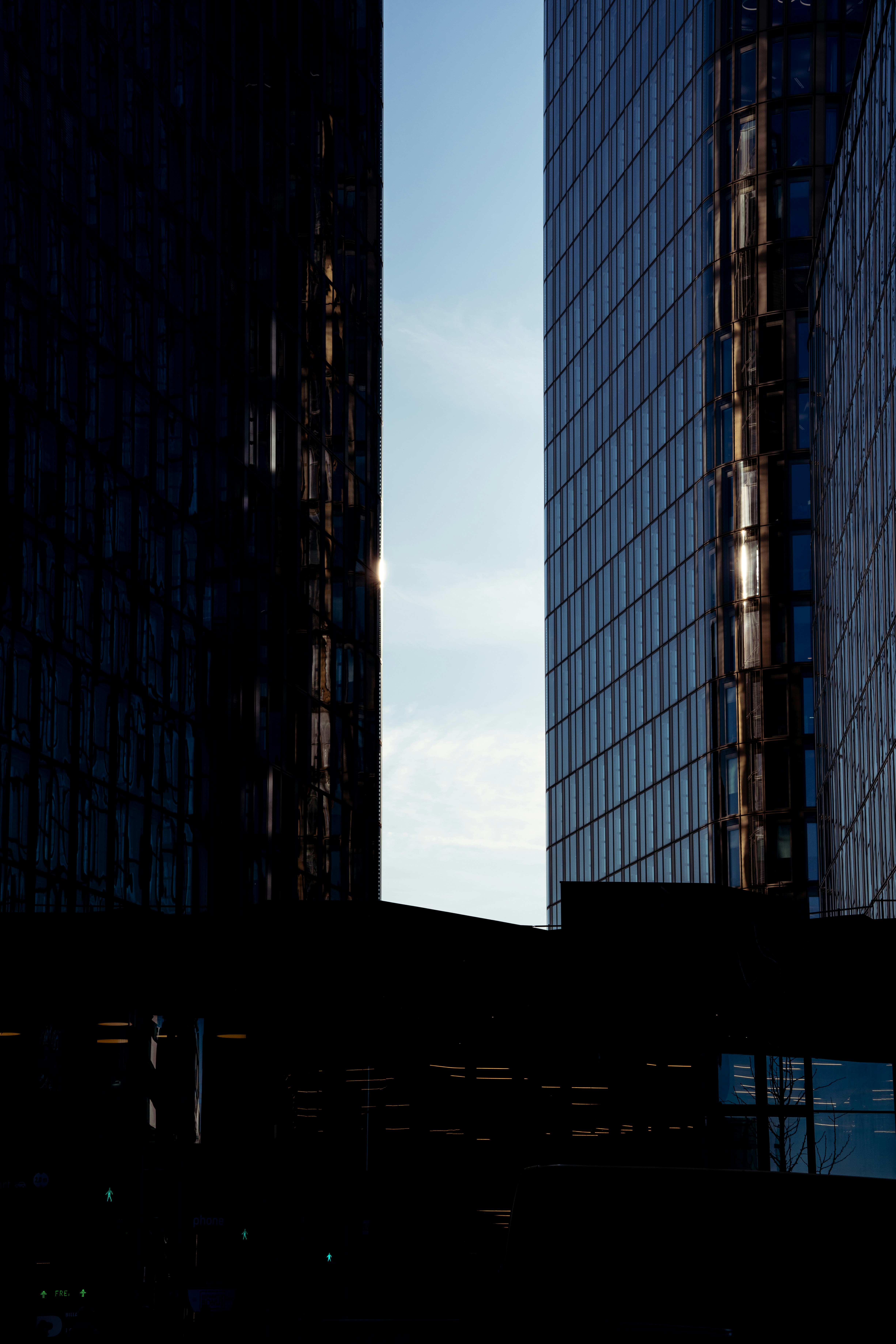 Skyscrapers frame a sliver of blue sky.
