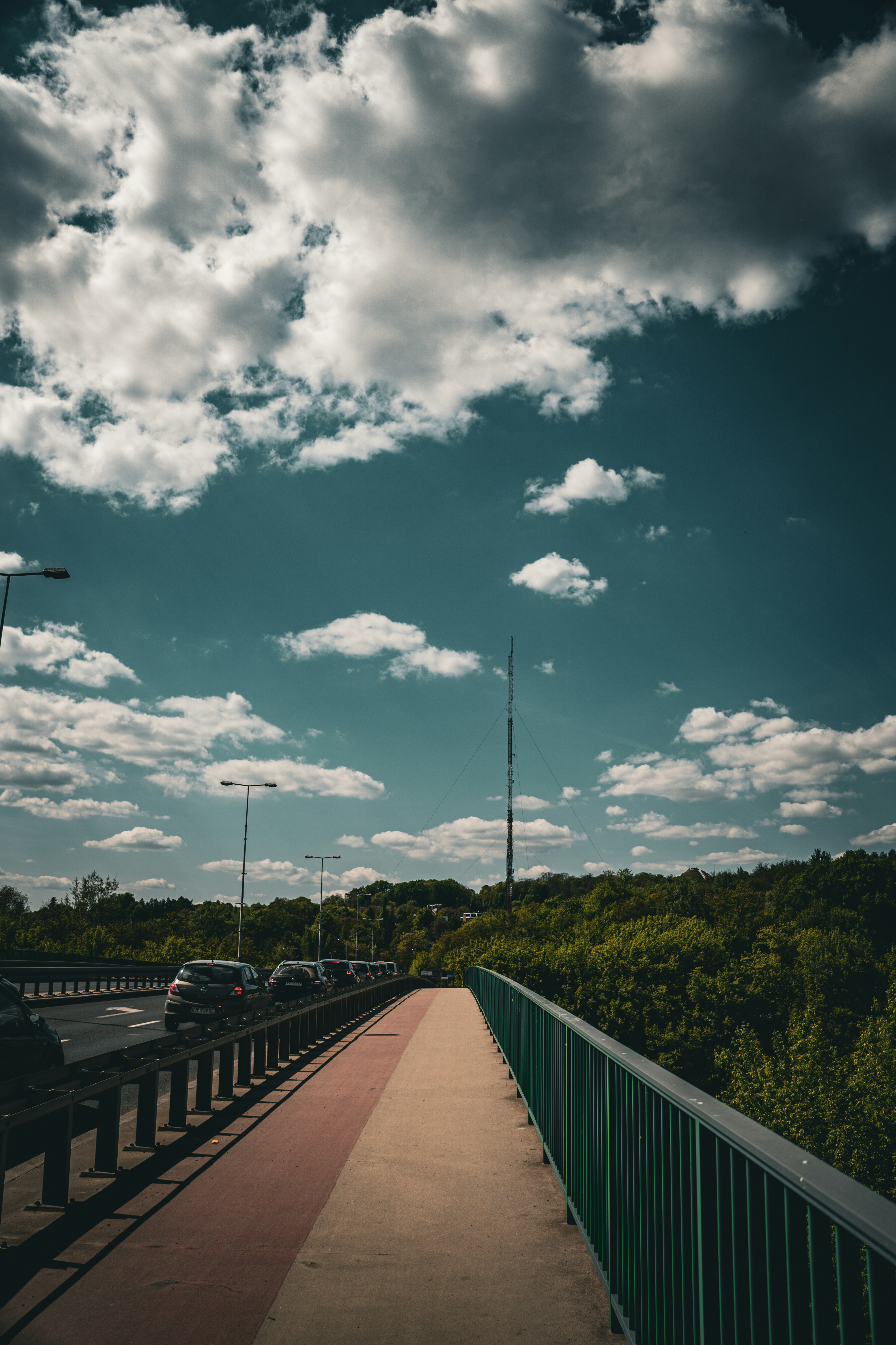 Cars and a bridge beneath a cloudy sky.