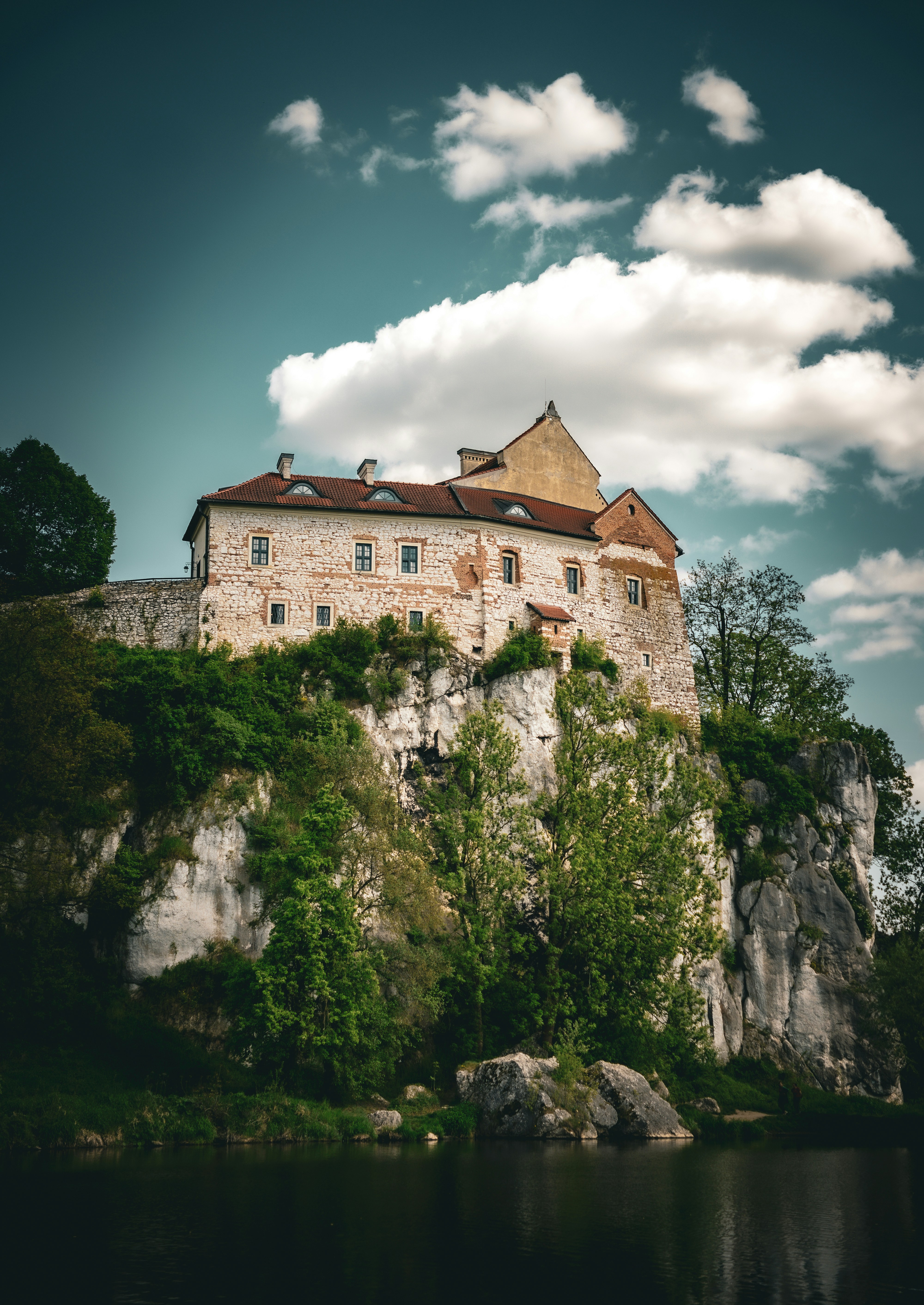 A stone castle towers high above the water.