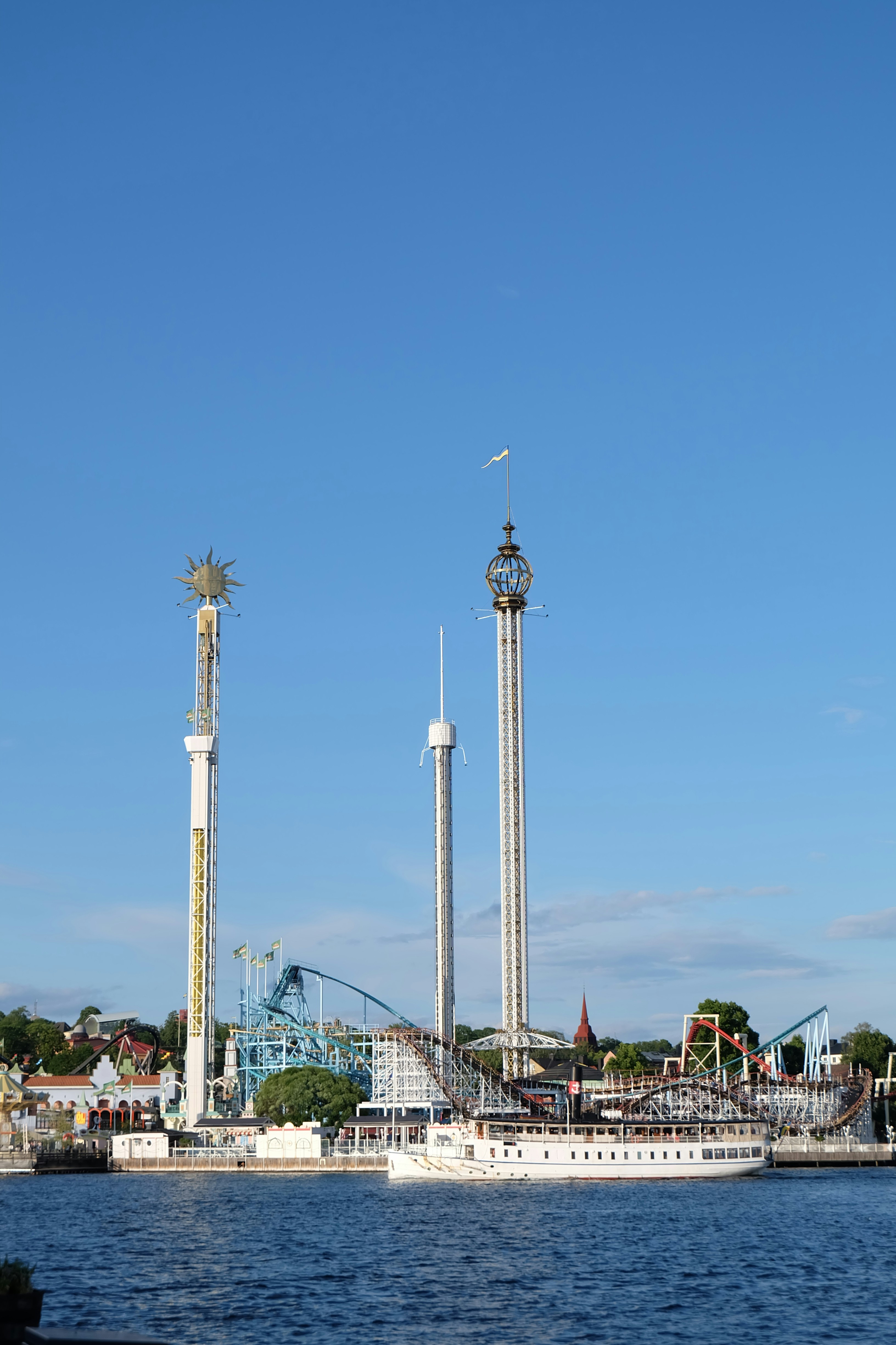 Amusement park towers stand tall against the blue sky.