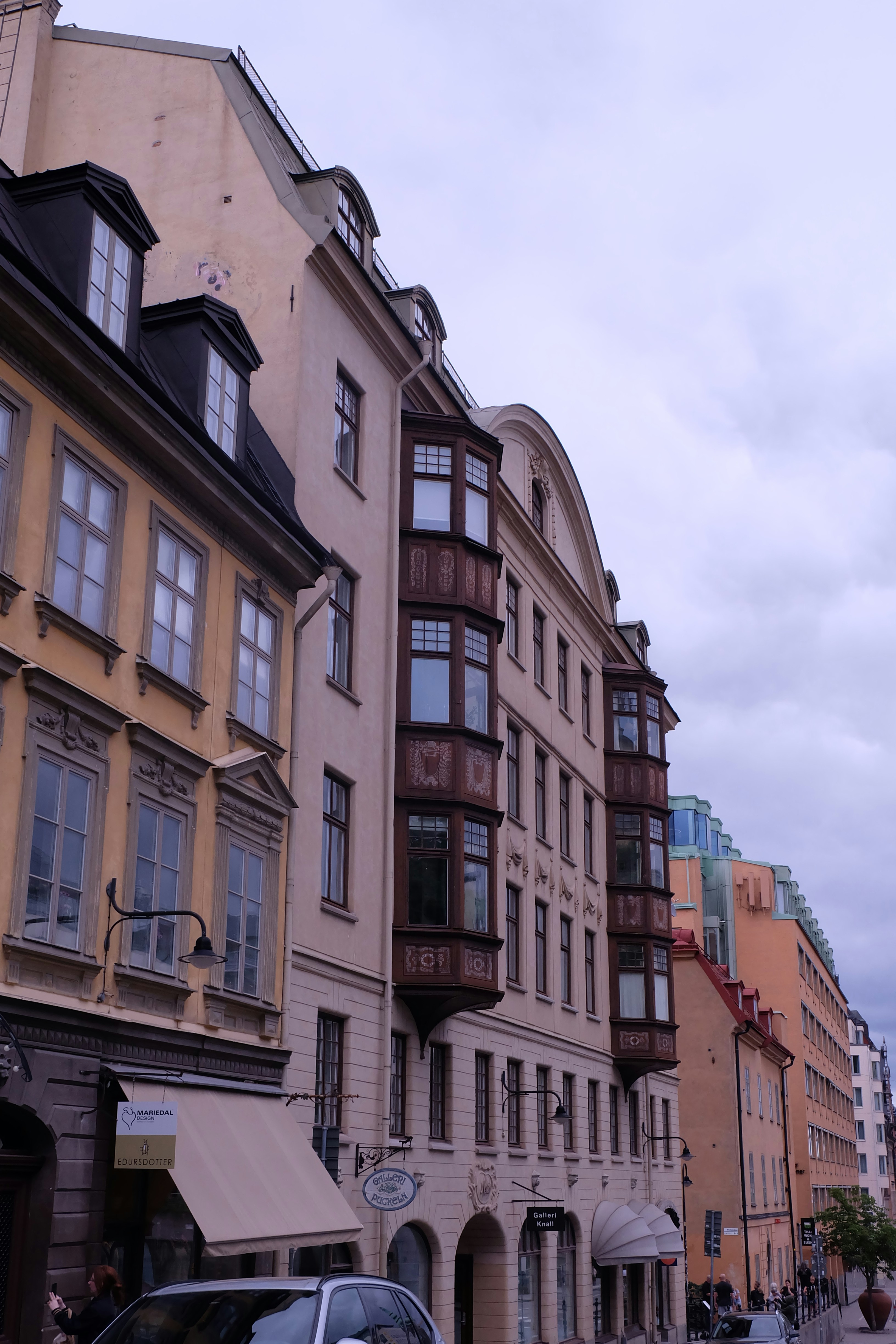 Elegant buildings showcasing a mix of historical and modern architectural styles along a city street.