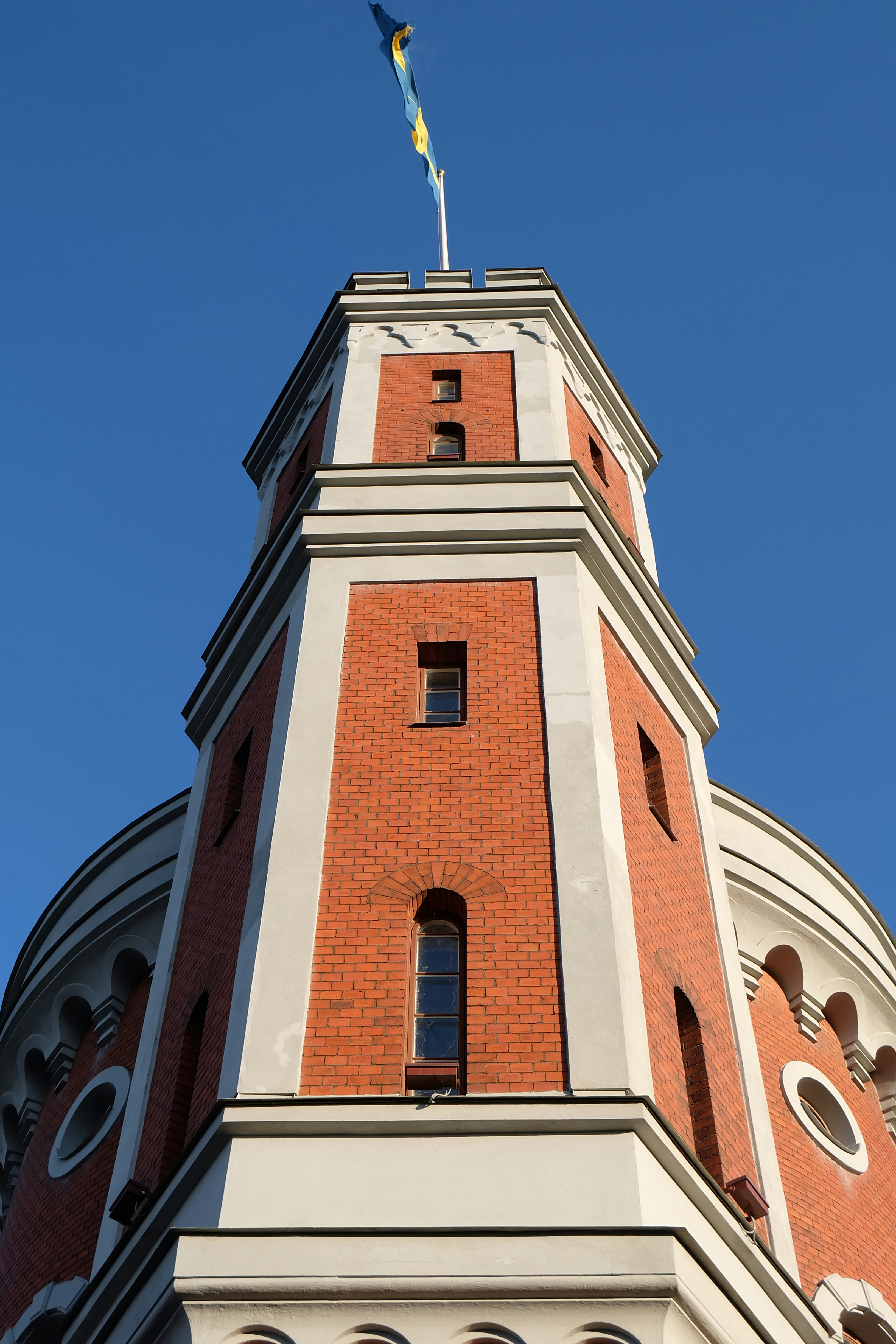 A tall brick tower with a flag.
