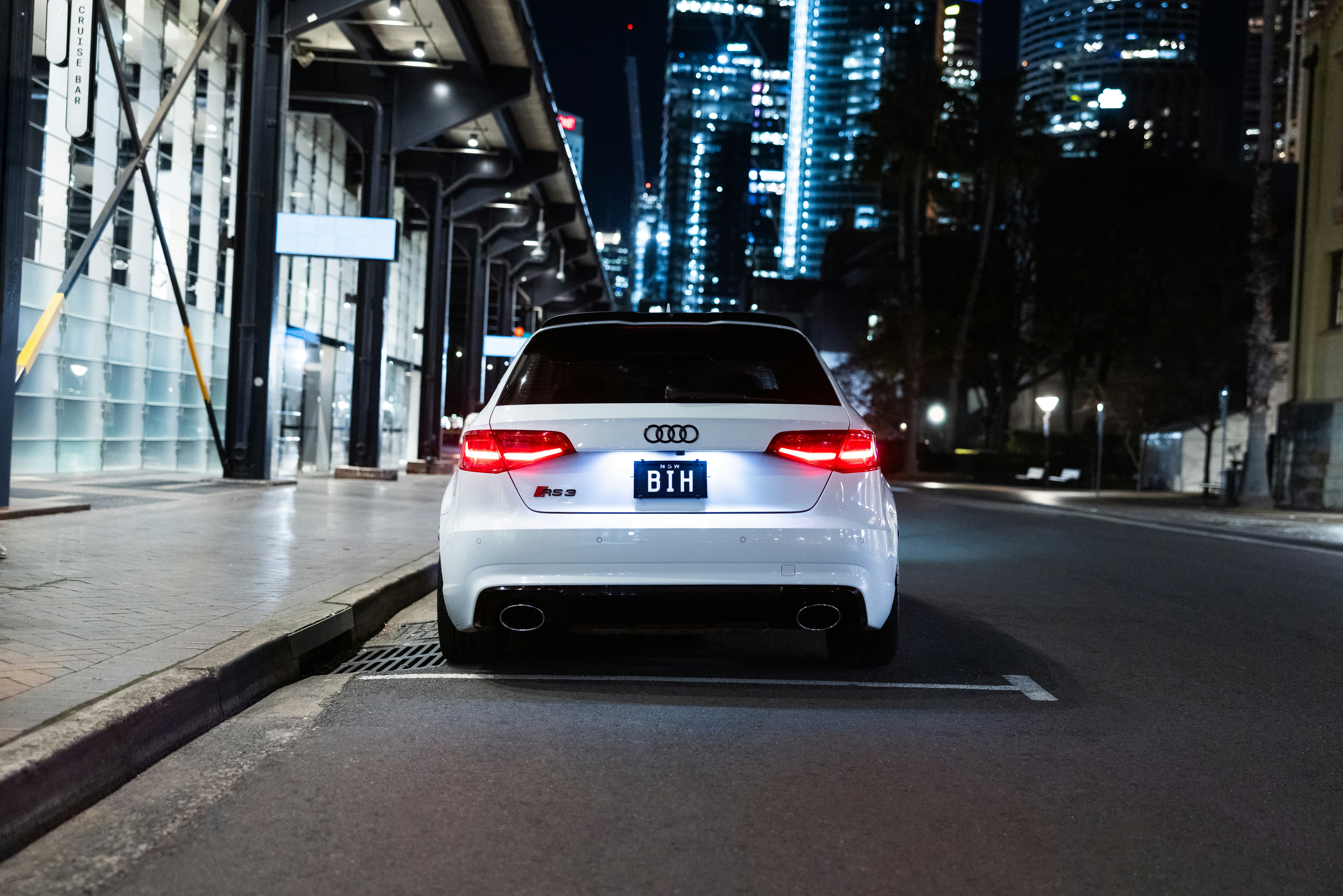 Midnight Stopover: White Audi Backlit by Neon City