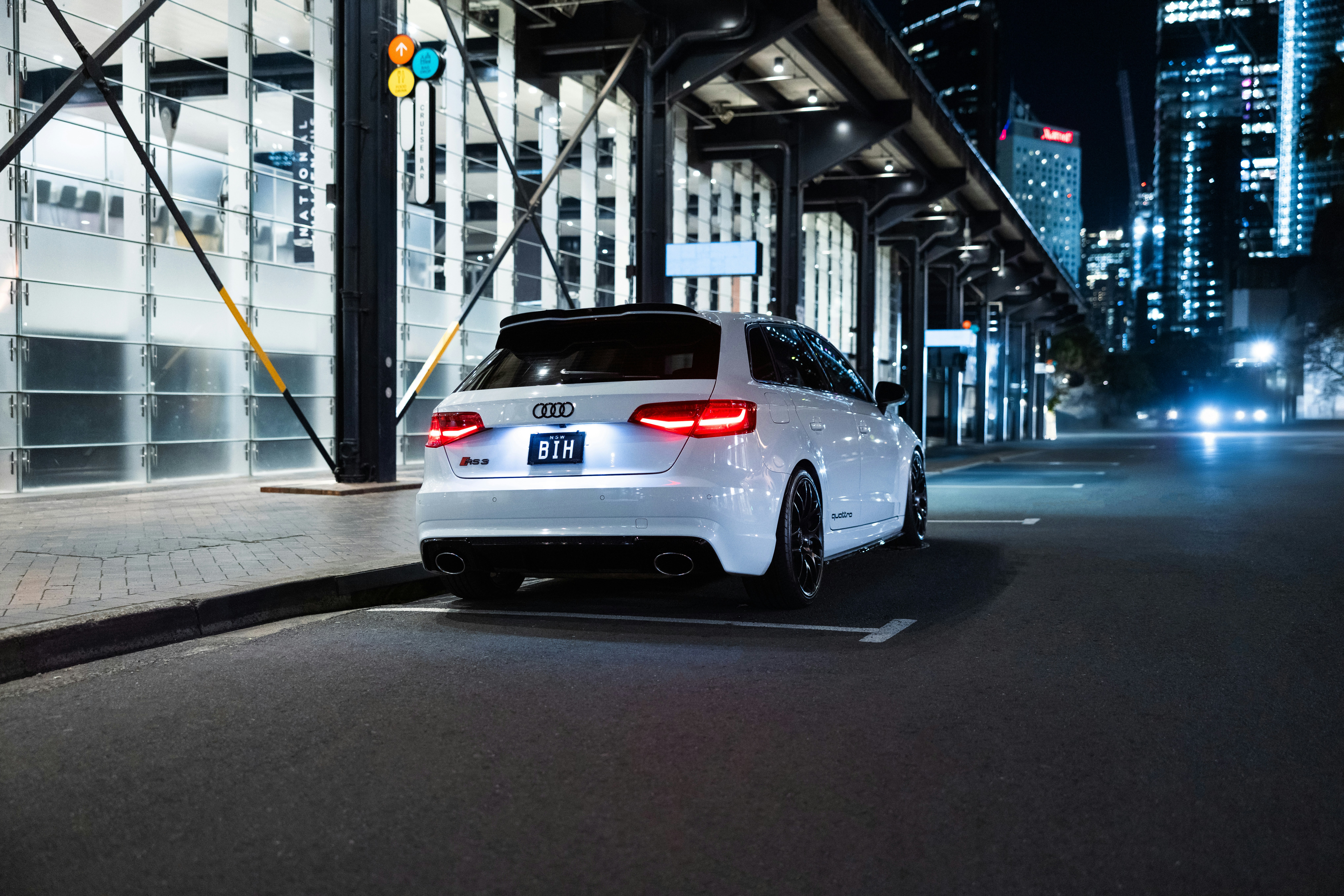 Neon Reflections: Night-Drive Audi Under a Glass Canopy