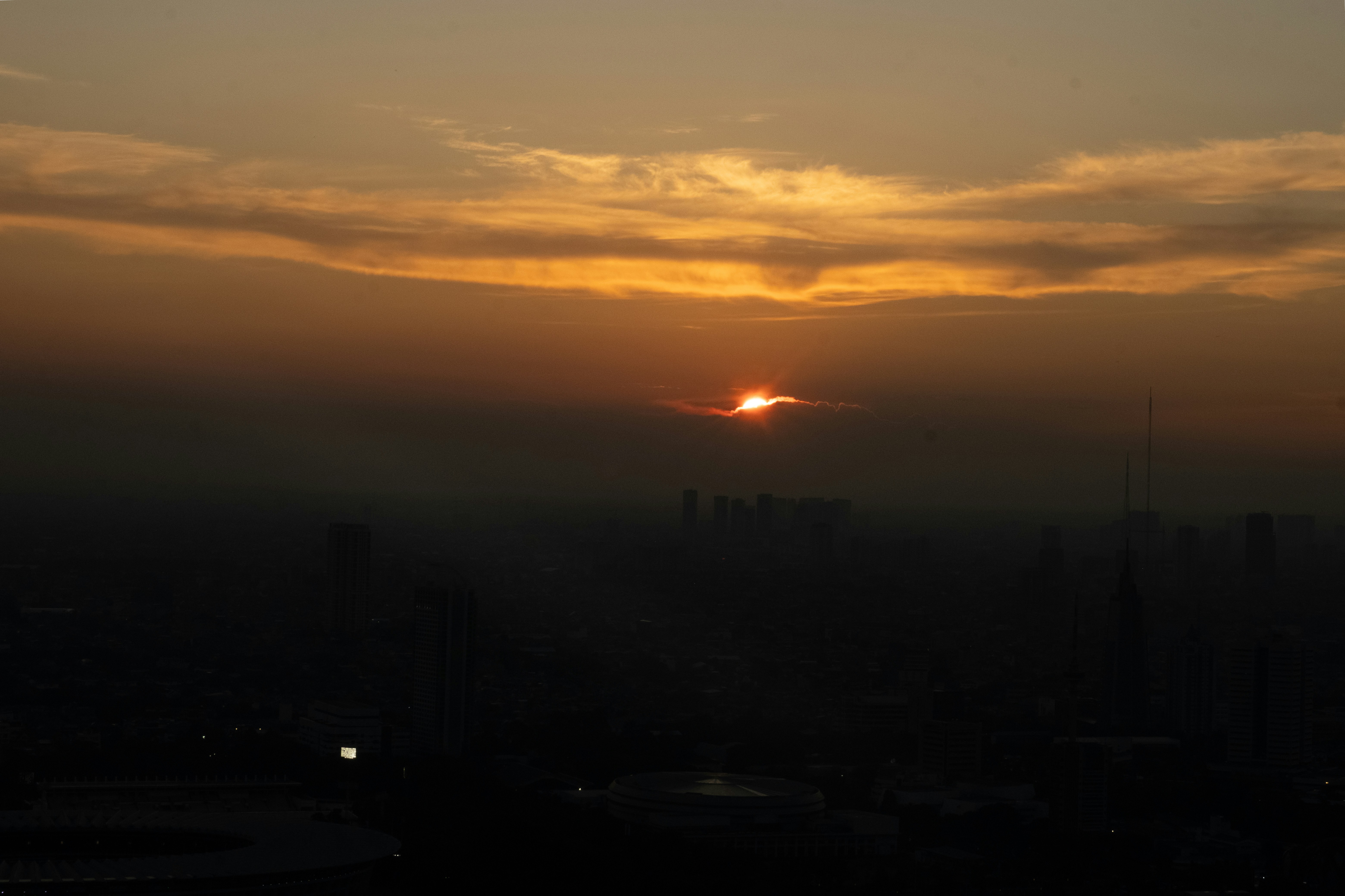 Sunset over a dark cityscape.