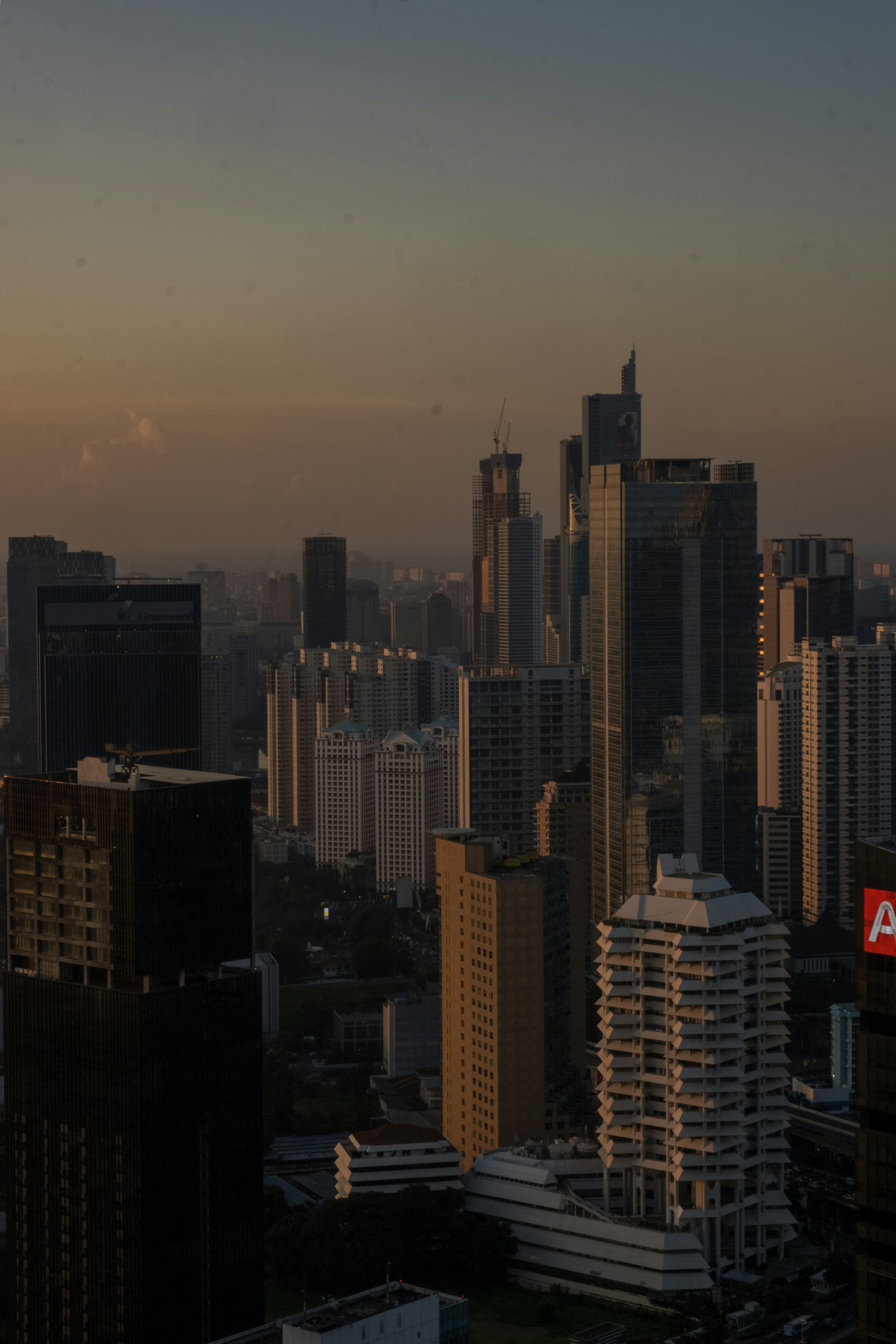 City skyline featuring a mix of modern skyscrapers and architectural designs under a soft twilight glow.