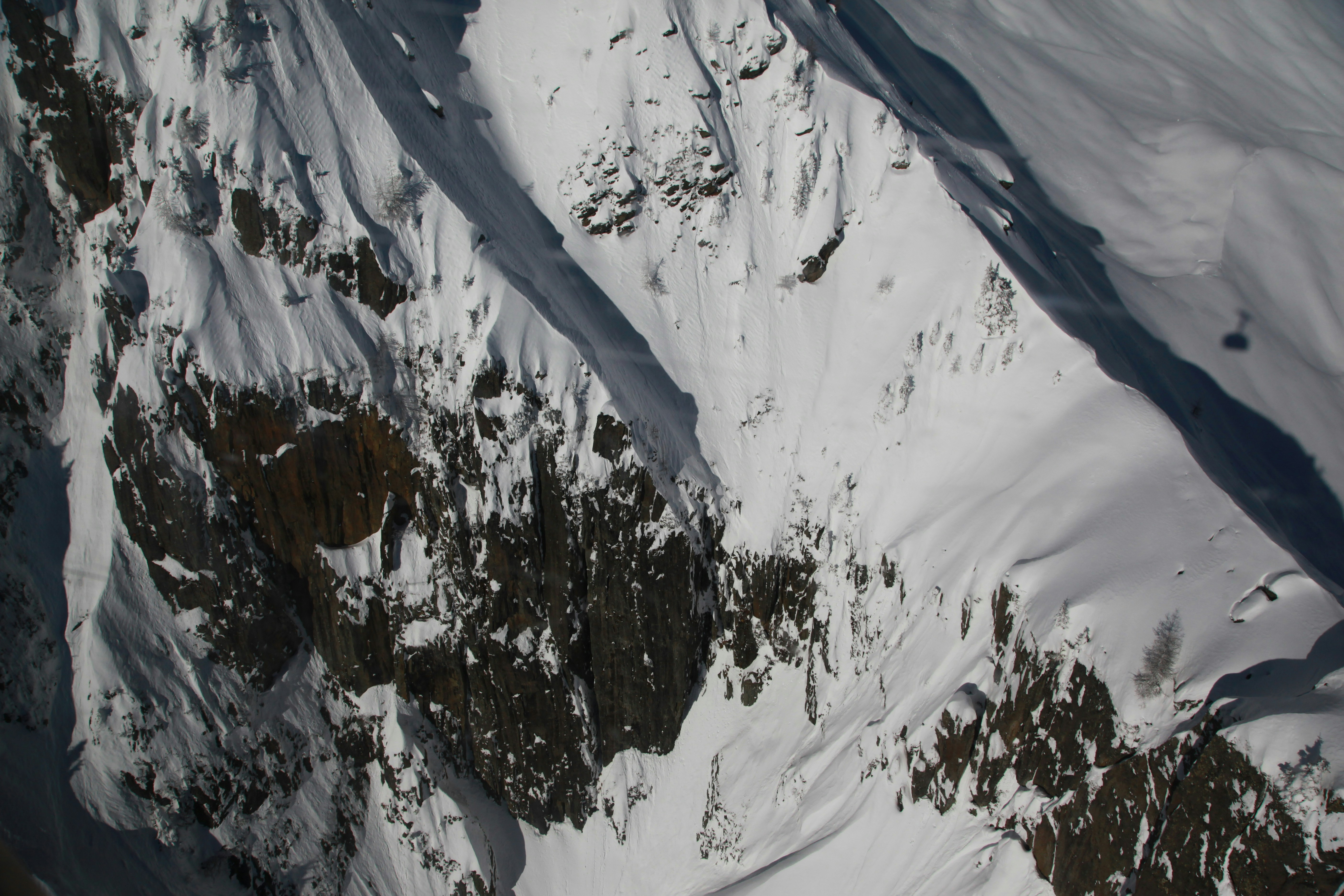 Snow-covered mountain slopes reveal rugged cliffs and a serene winter landscape.