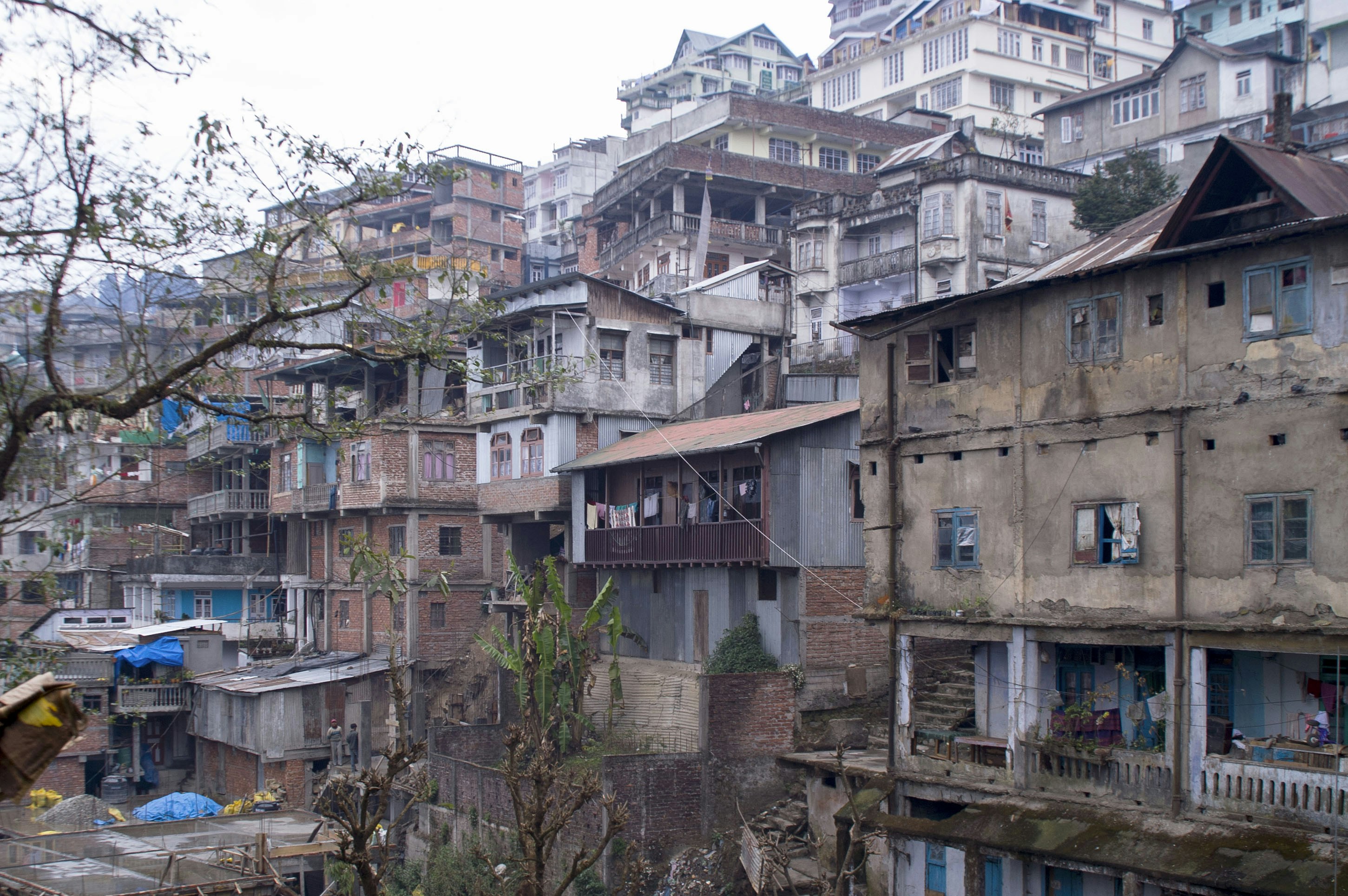 A densely populated hillside showcasing a mix of residential structures, reflecting the intricate lifestyle of urban dwellers. The scene highlights the contrast between different architectural styles and living conditions.
