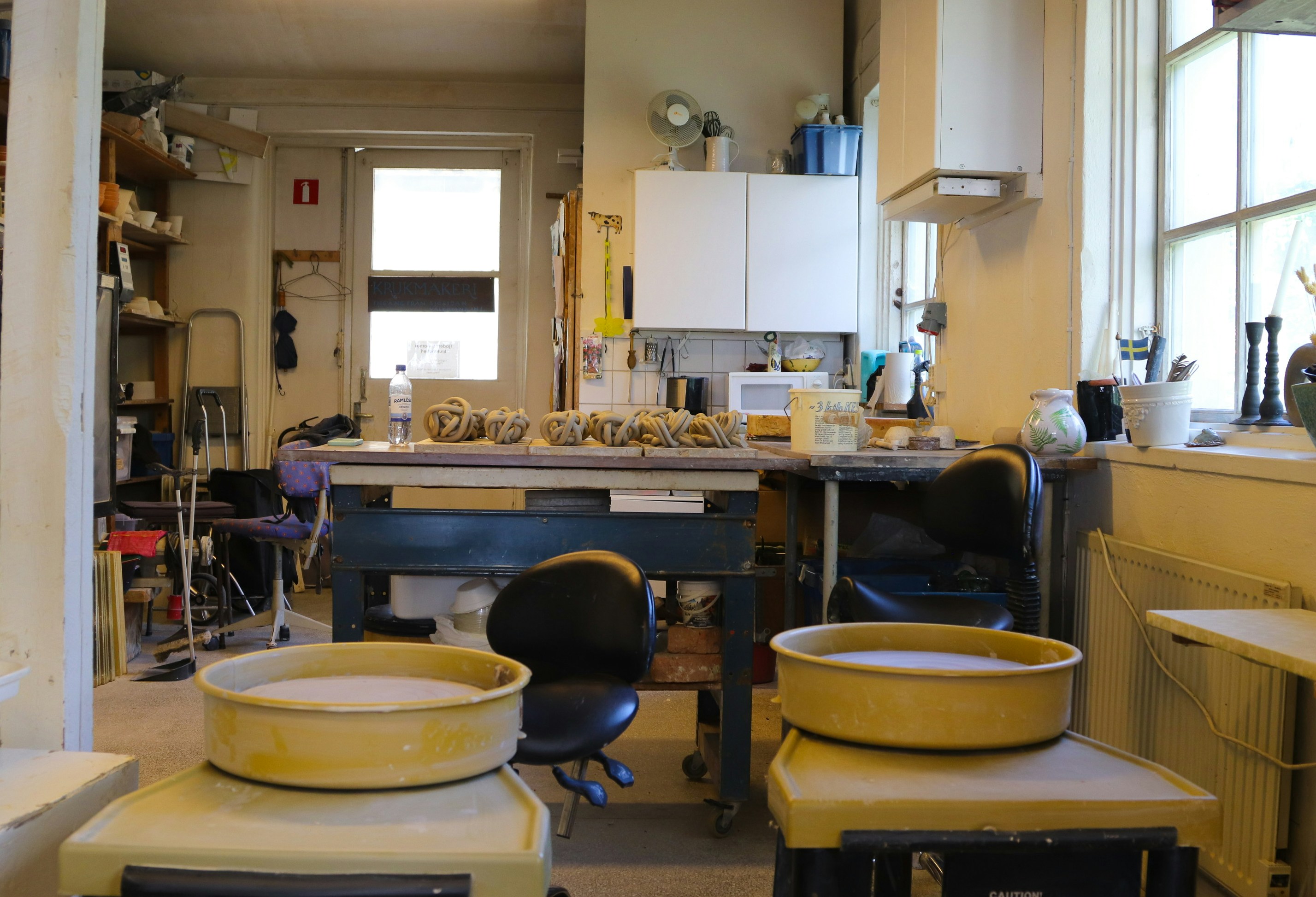 Sunlit Ceramics Studio: Foreground Basins Anchor a Quiet Workshop
