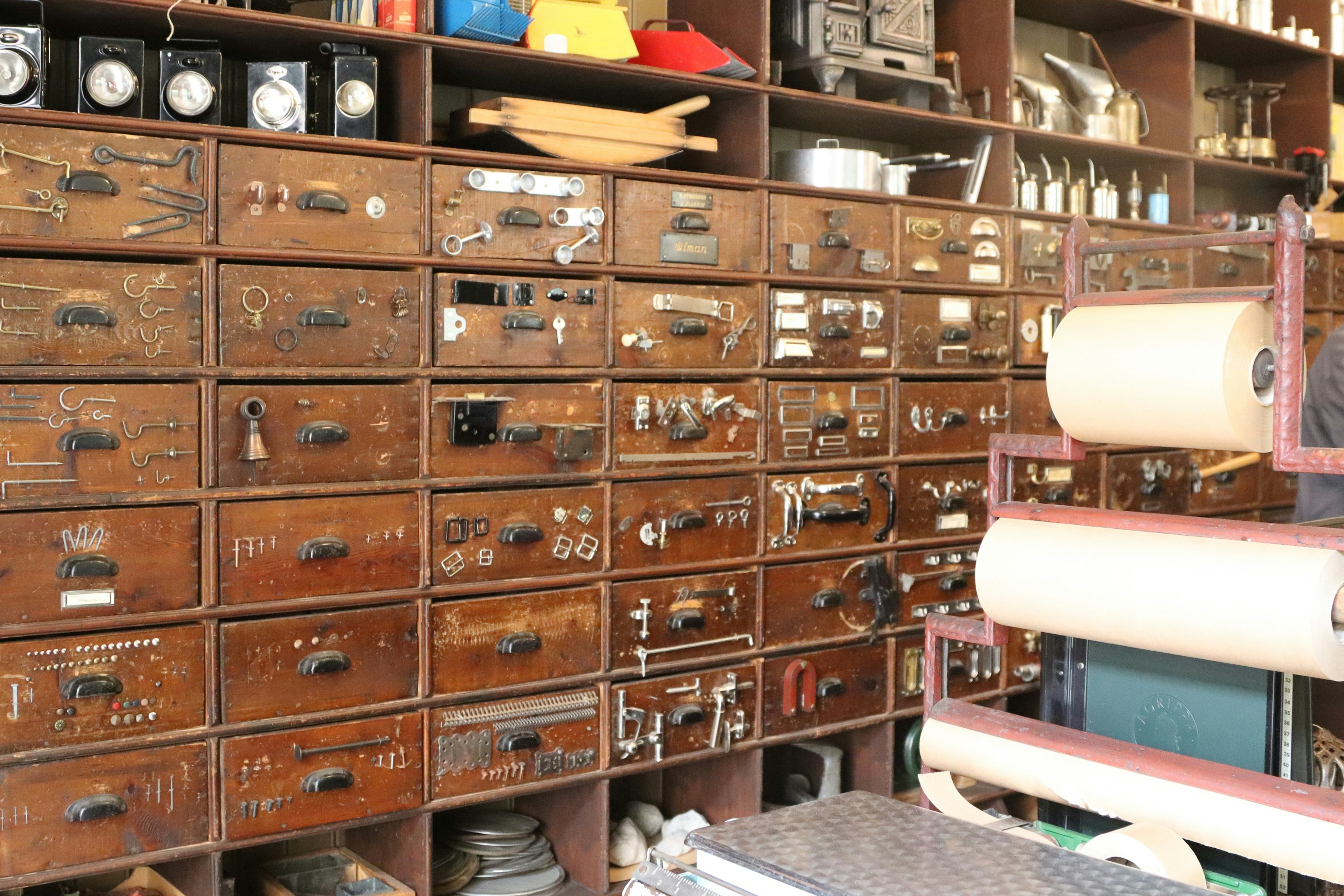 A meticulously organized collection of vintage drawers filled with various tools and hardware, showcasing a rich history of craftsmanship.