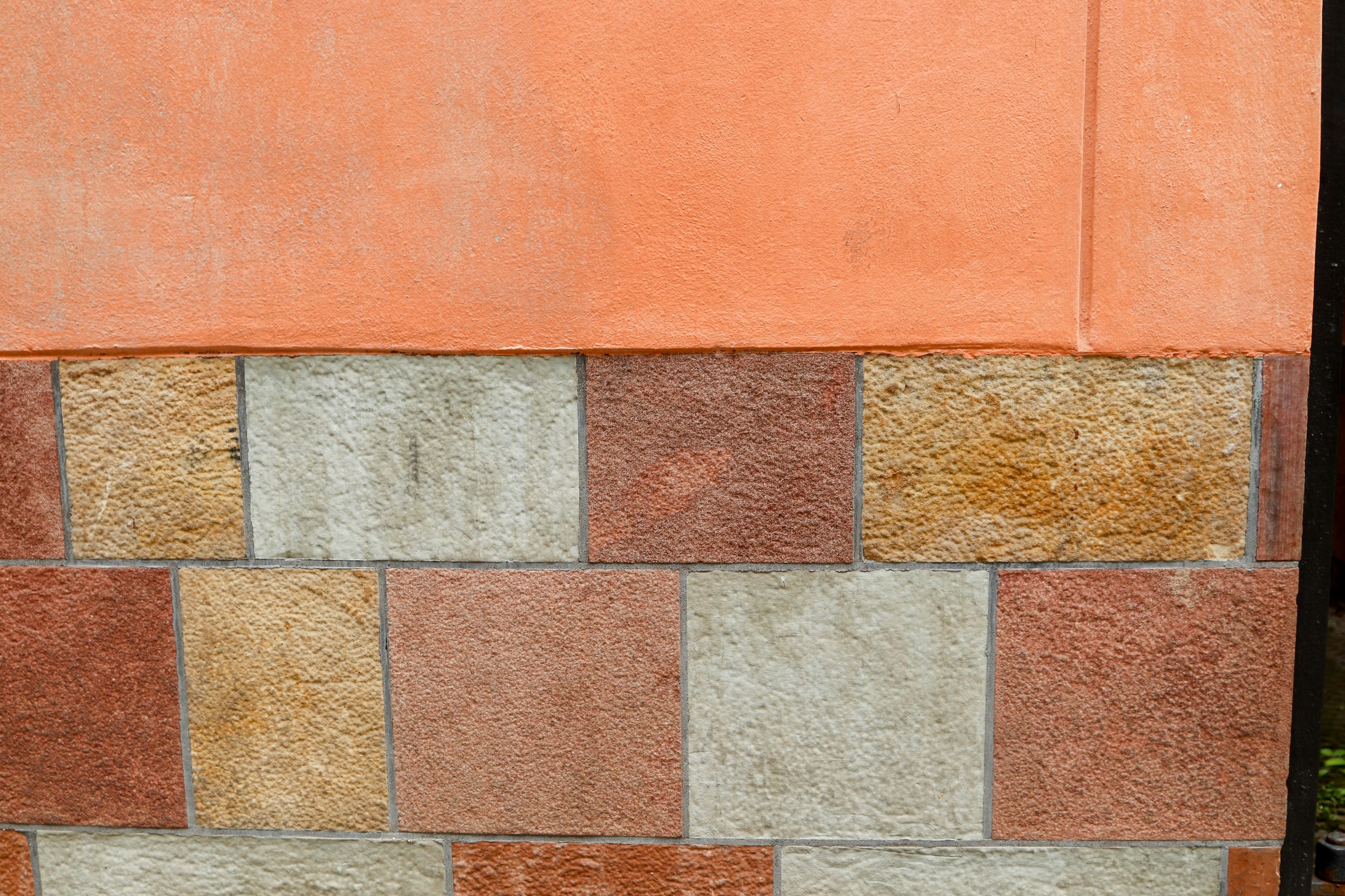 Orange wall with a tiled base.
