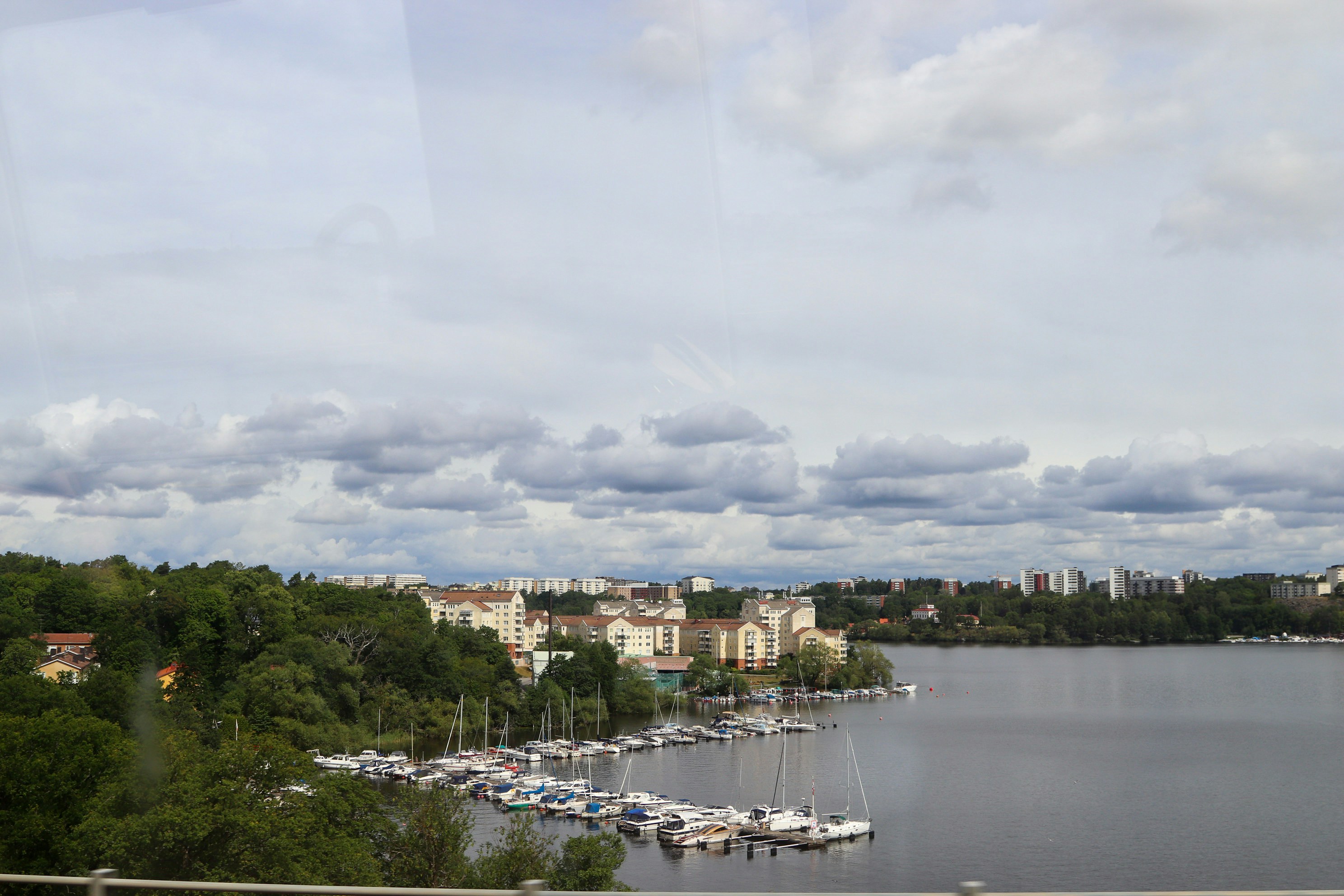 A harbor with boats and buildings under a cloudy sky.