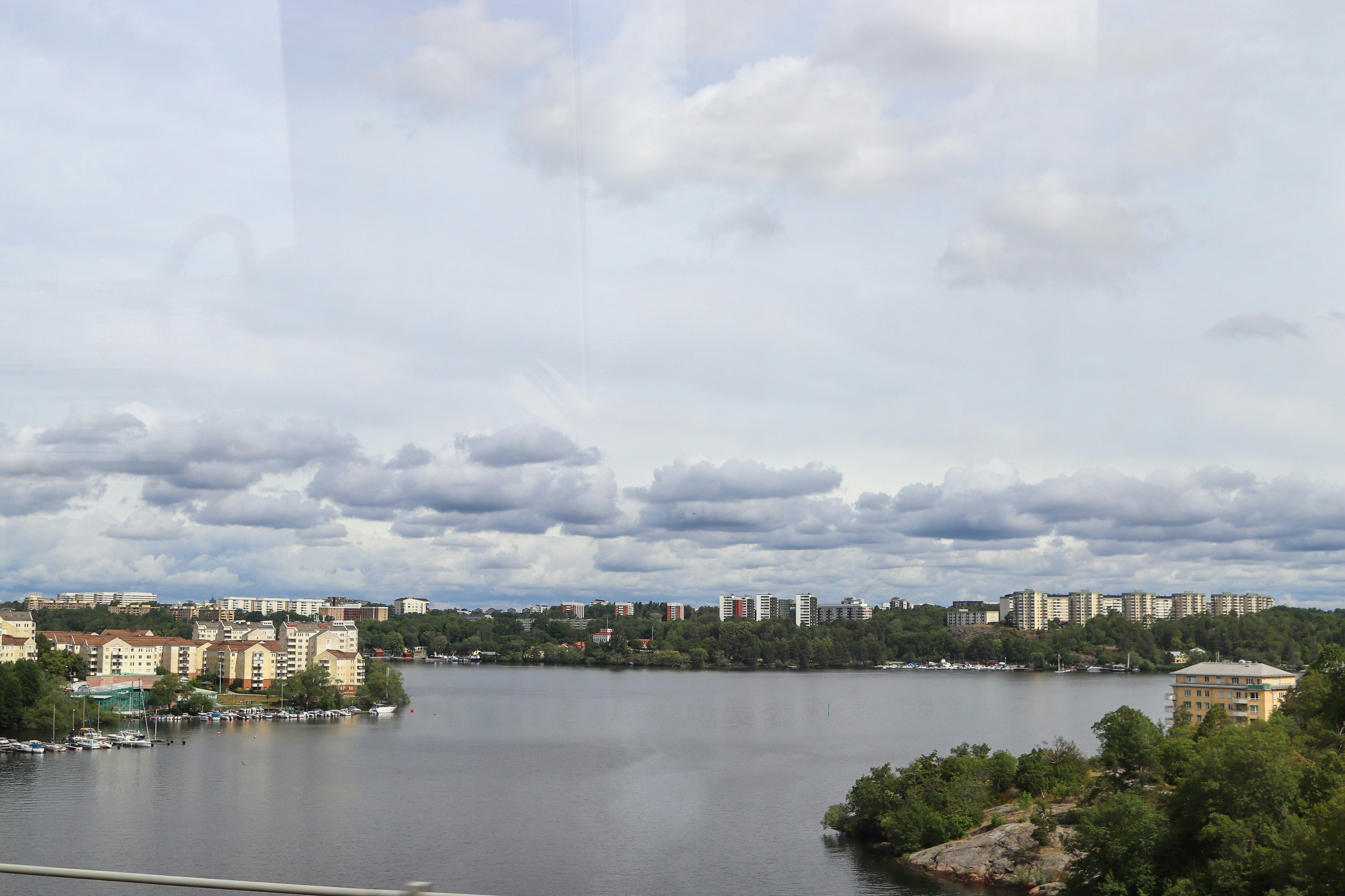 A lake view with city buildings and cloudy skies.