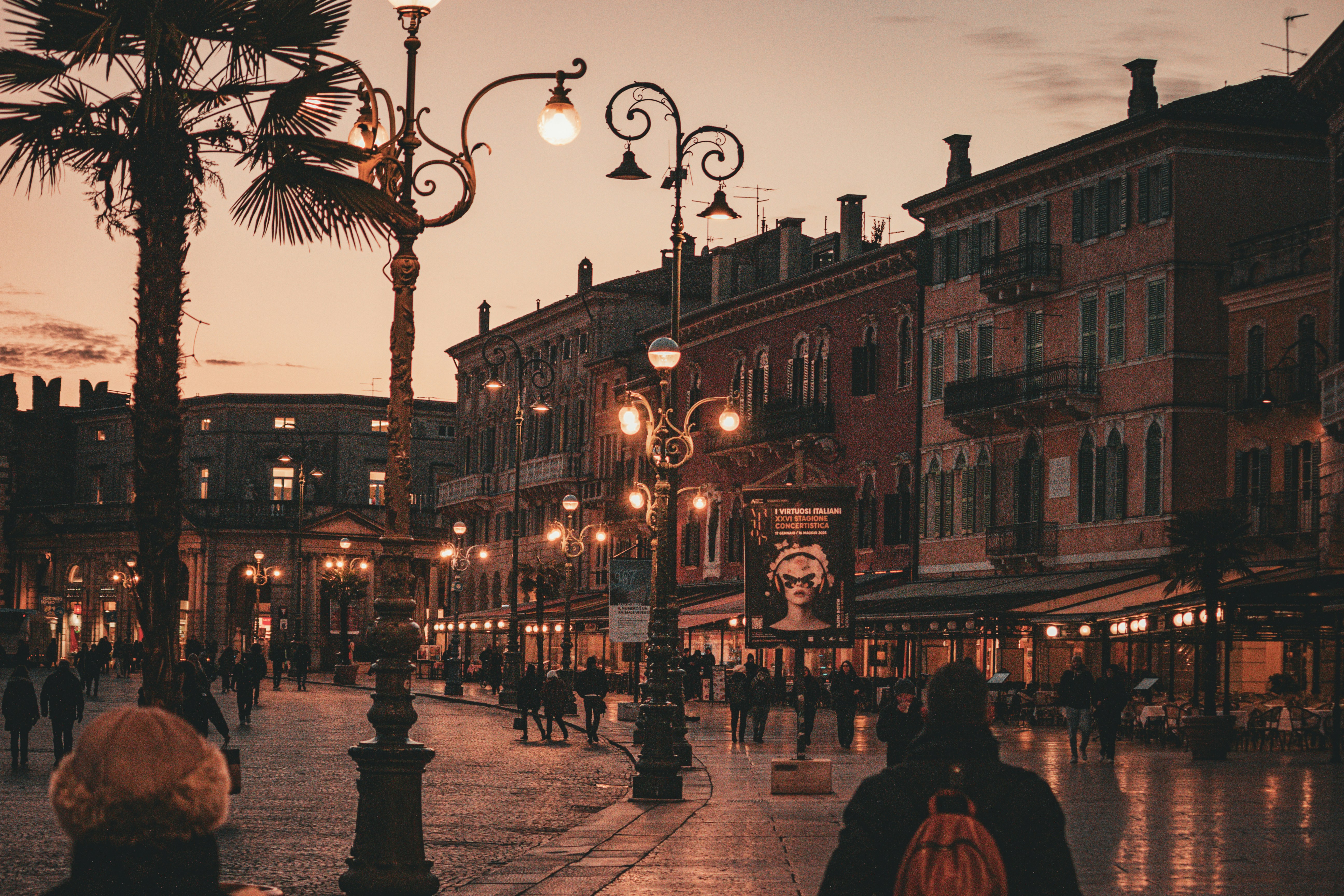Verona at sunset | A city street scene lit by streetlights at dusk.