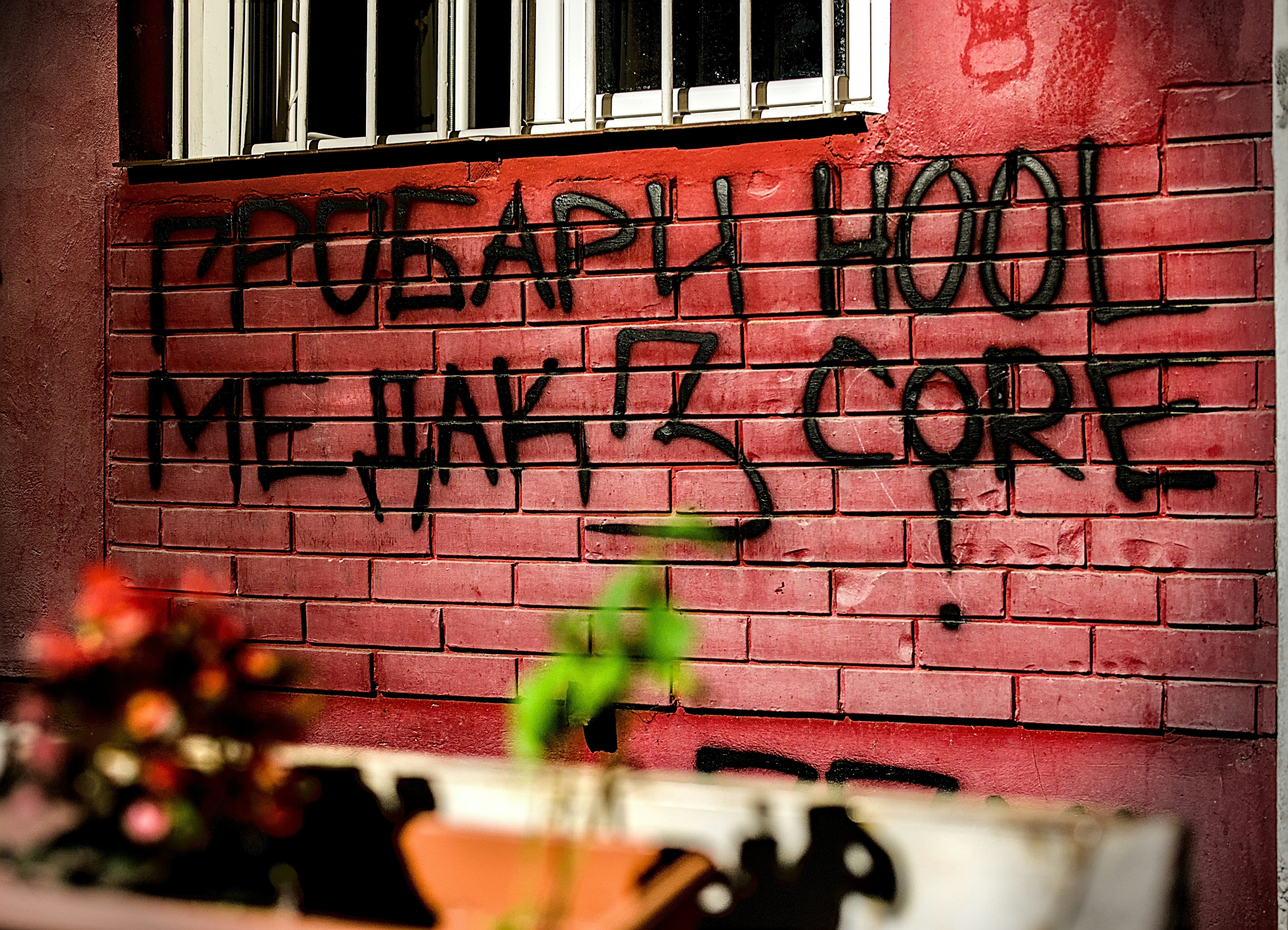 Graffiti is on a brick wall.