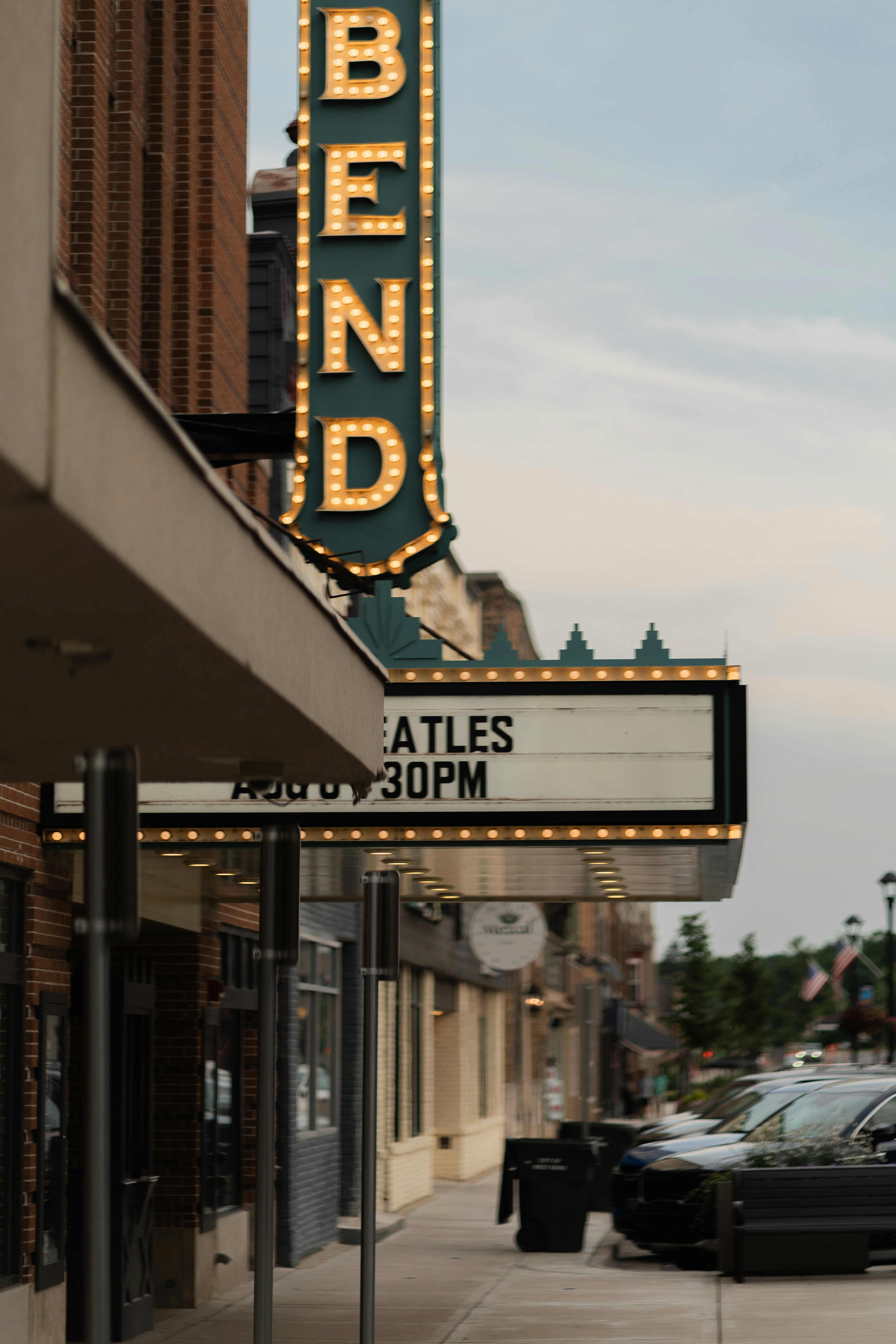 Vintage theater marquee displaying 'The Beatles' with illuminated letters against a twilight sky.