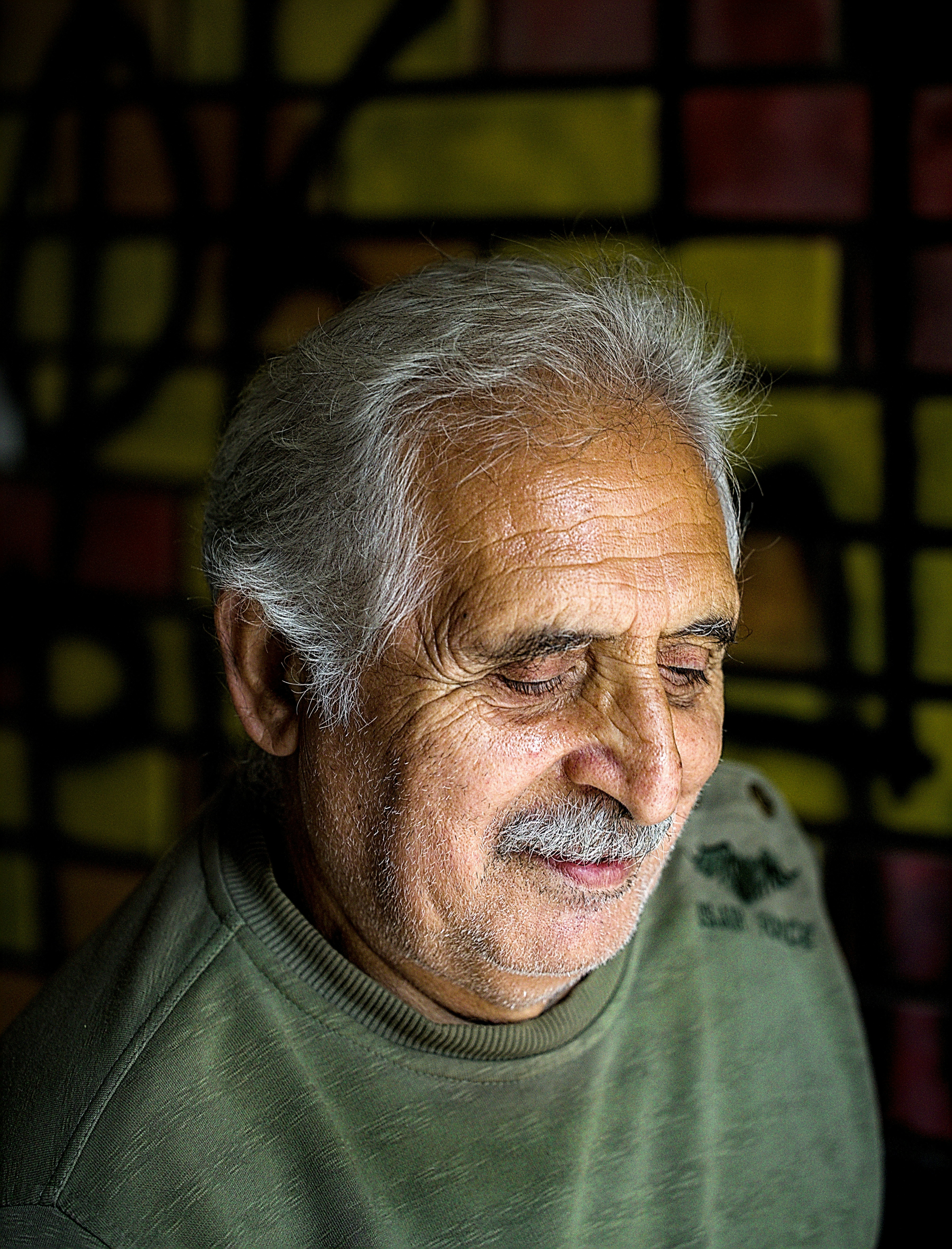 A smiling elderly man poses for a portrait.
