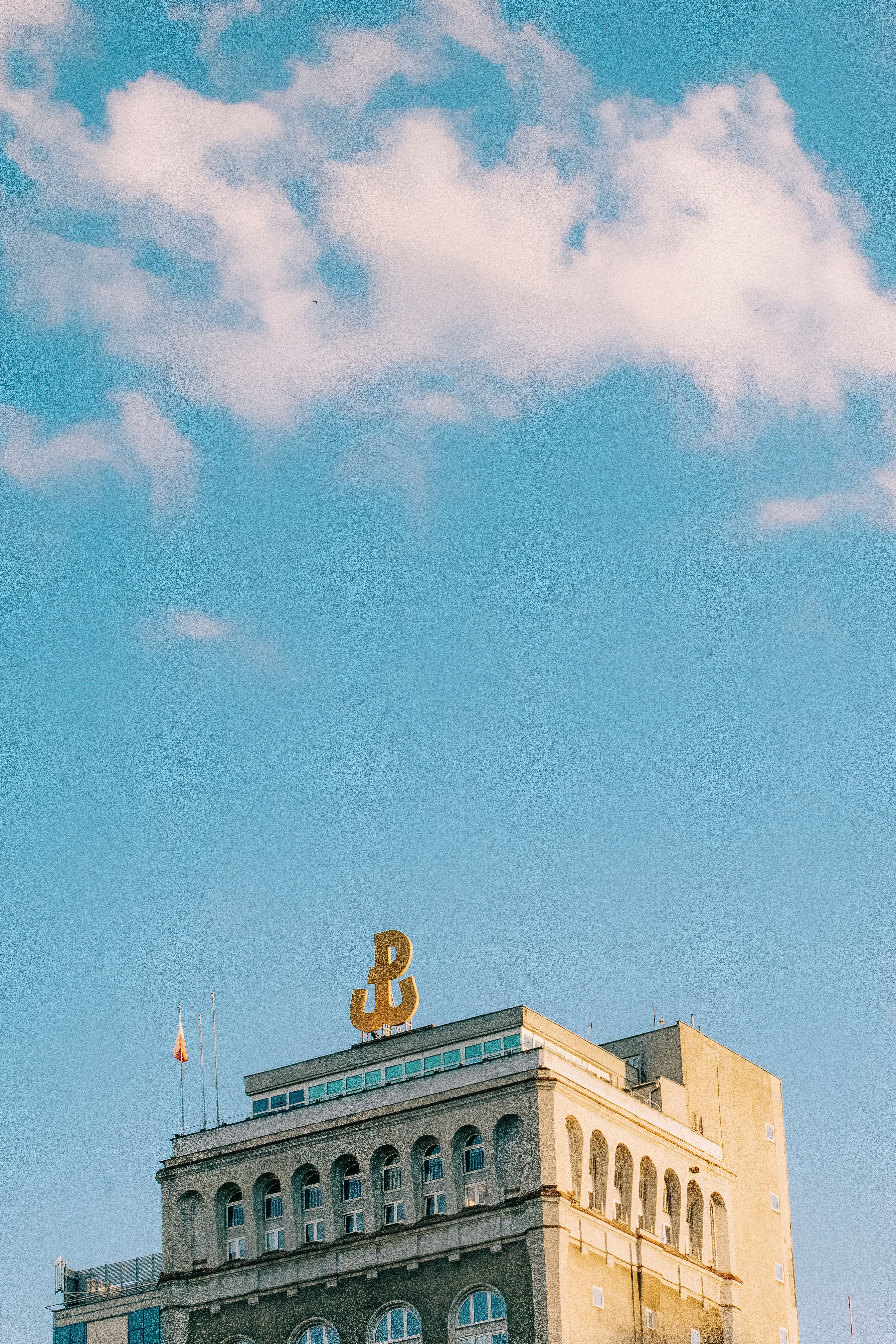 A building with a yellow anchor against a blue sky.