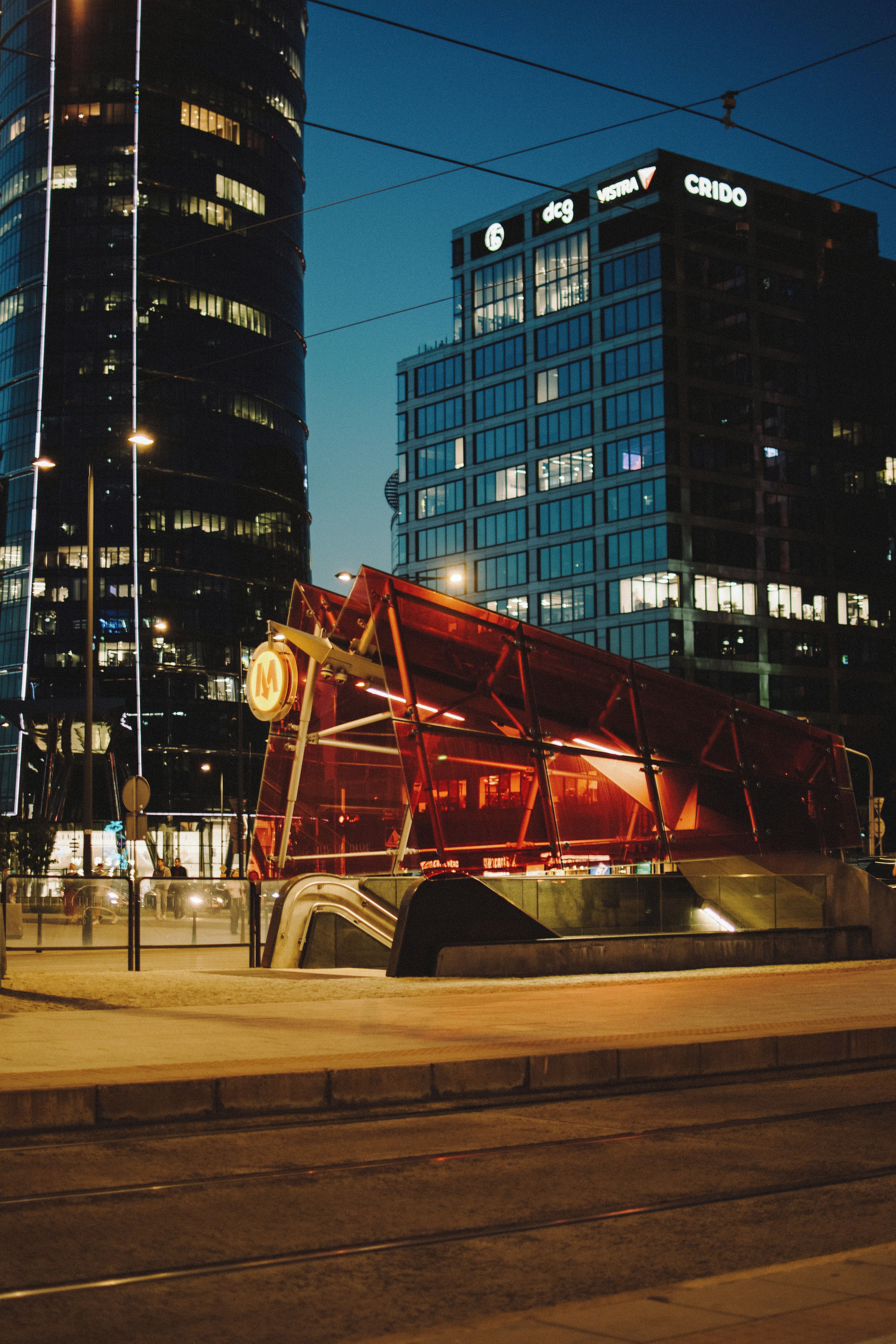 Crimson Glass Canopy Illuminates a Midnight Cityscape