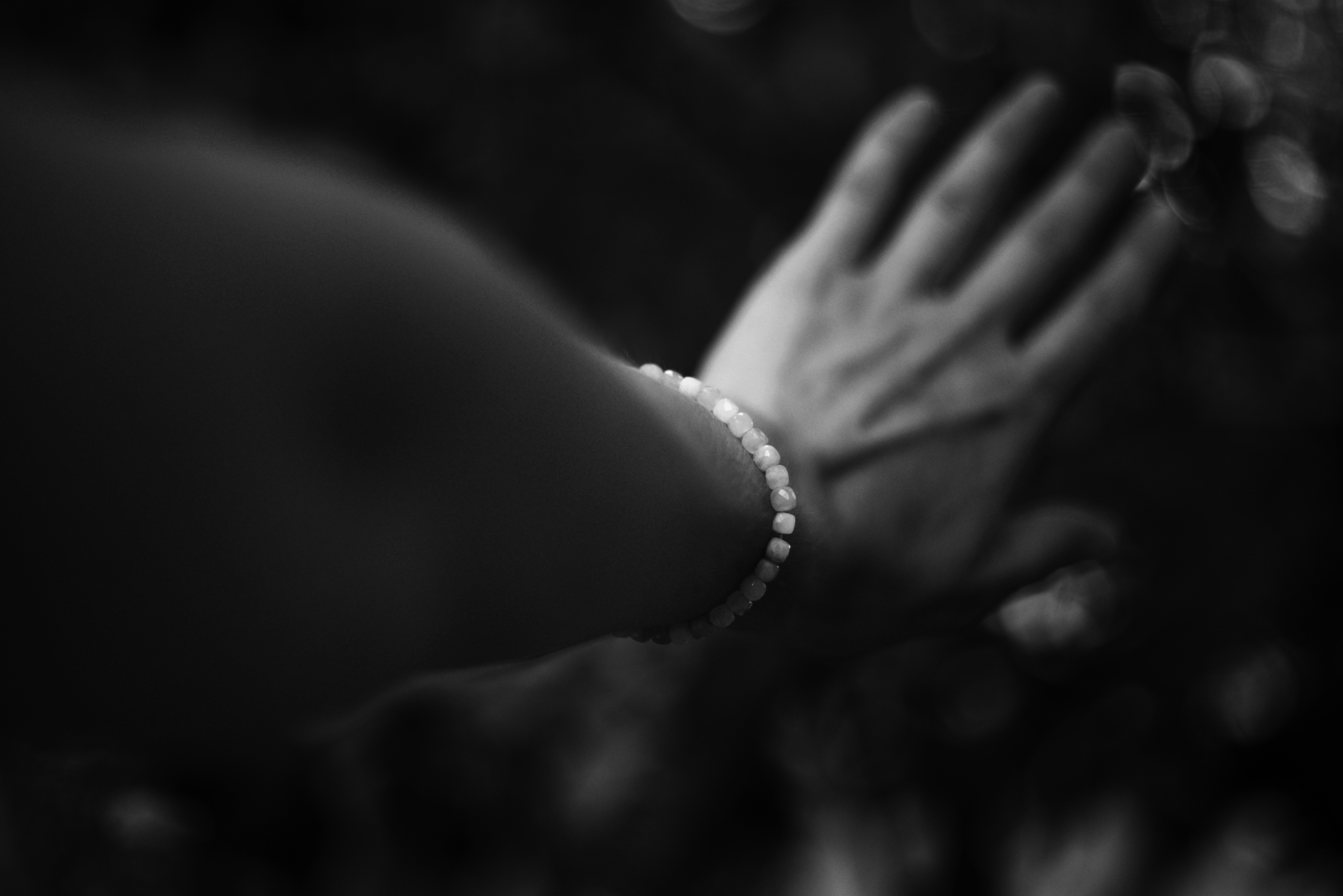 A hand reaches for something, black and white.