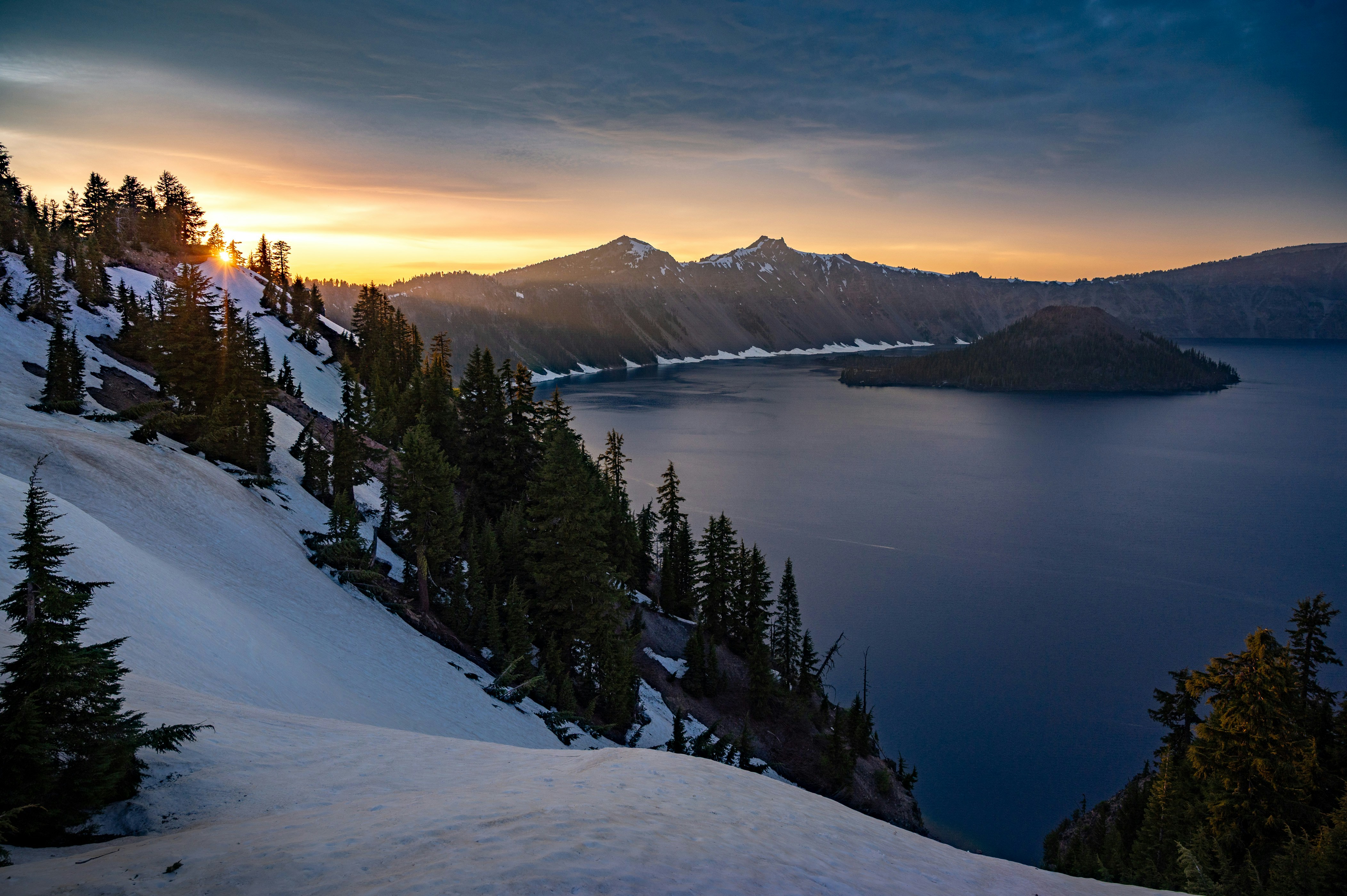 Sunset on the Snowbound Rim: An Alpine Lake Framed by Silent Pines