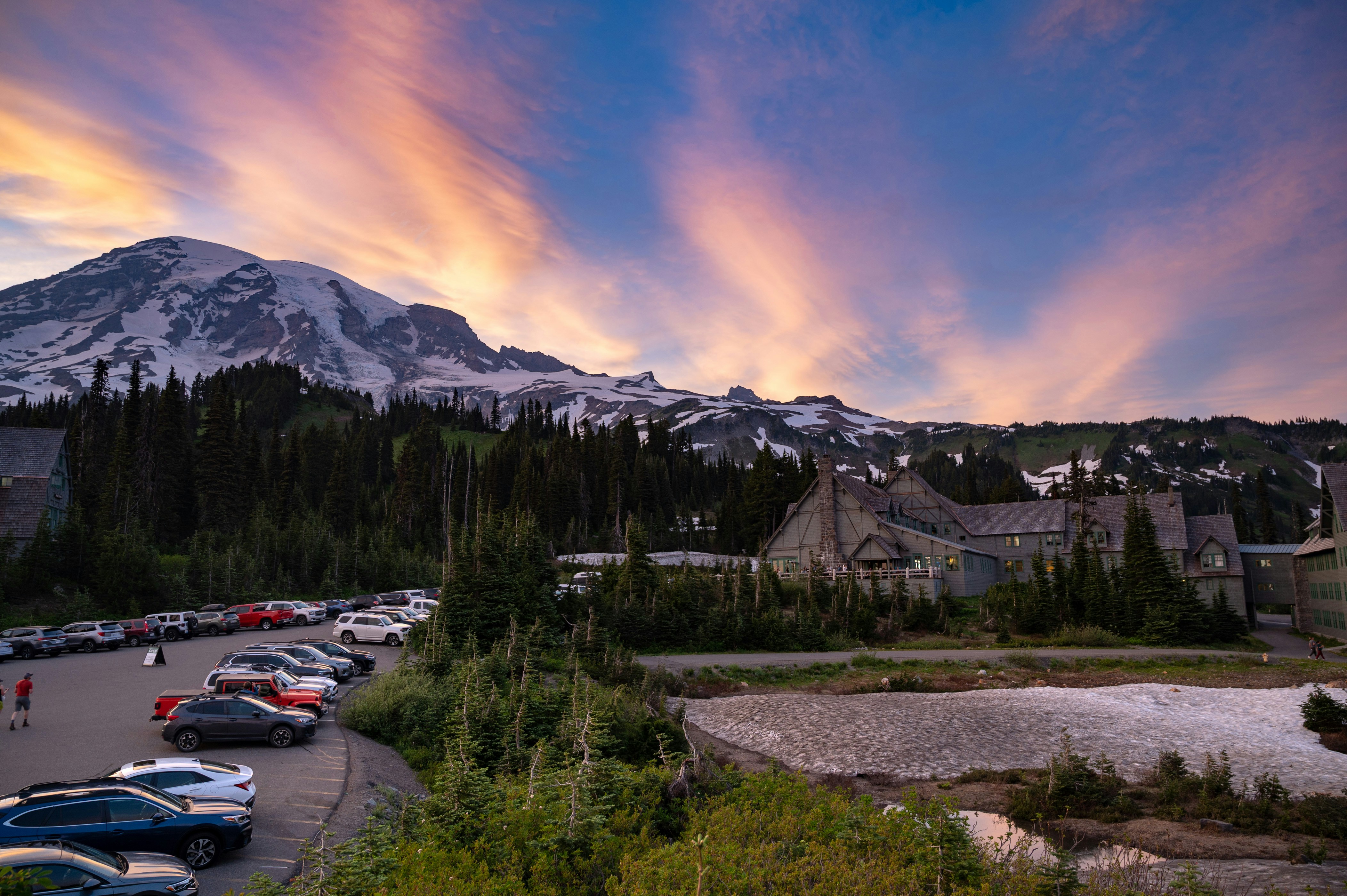 Sunset illuminates mount rainier and a lodge.
